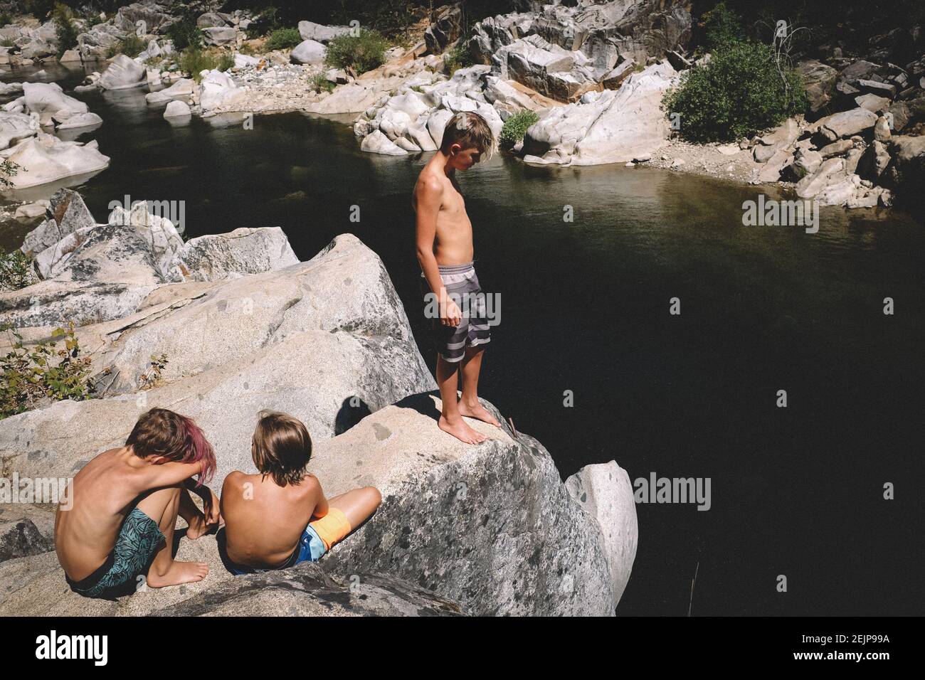 Boys Survey the Cliff Height above the River Stock Photo - Alamy