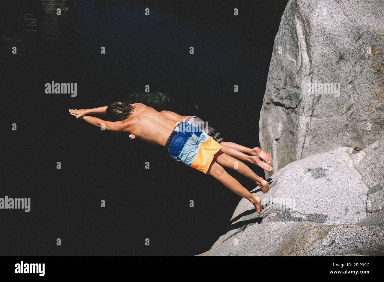 Two Boys Dive Together from a Cliff Edge Stock Photo - Alamy