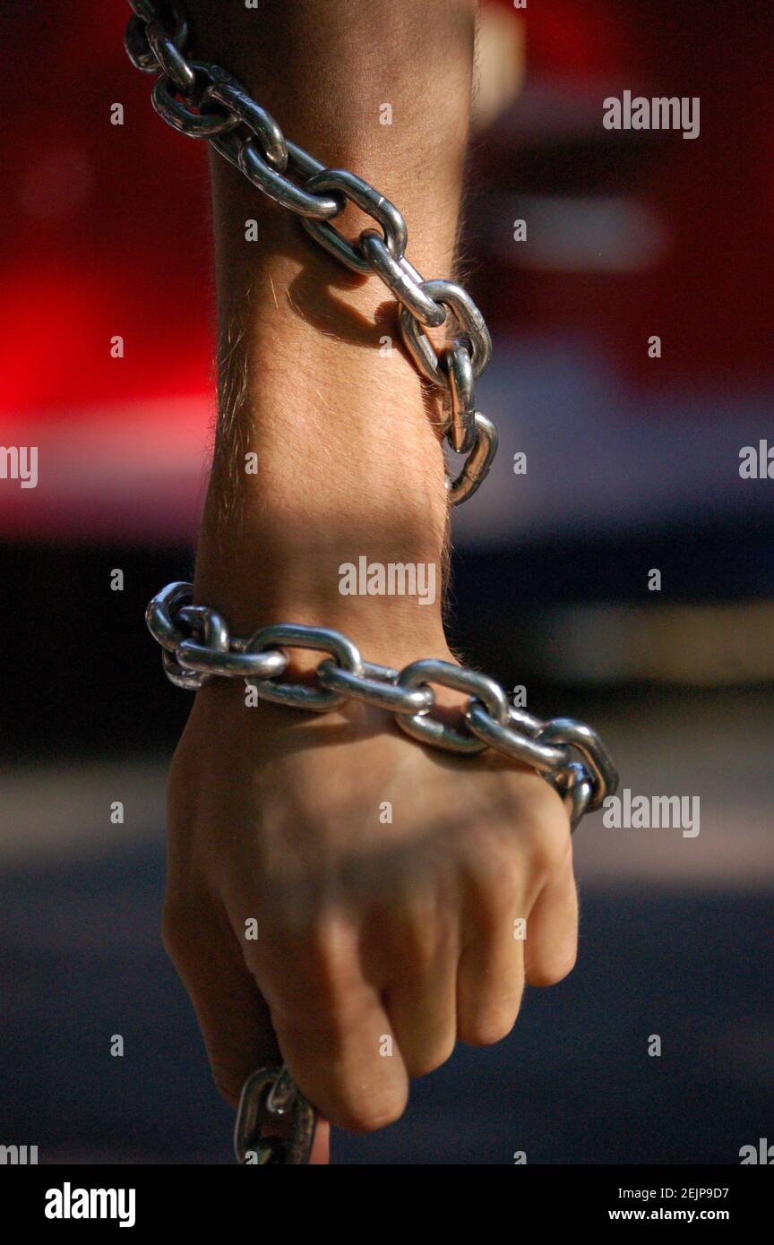 Metal chains wrapped on a male hand Stock Photo - Alamy