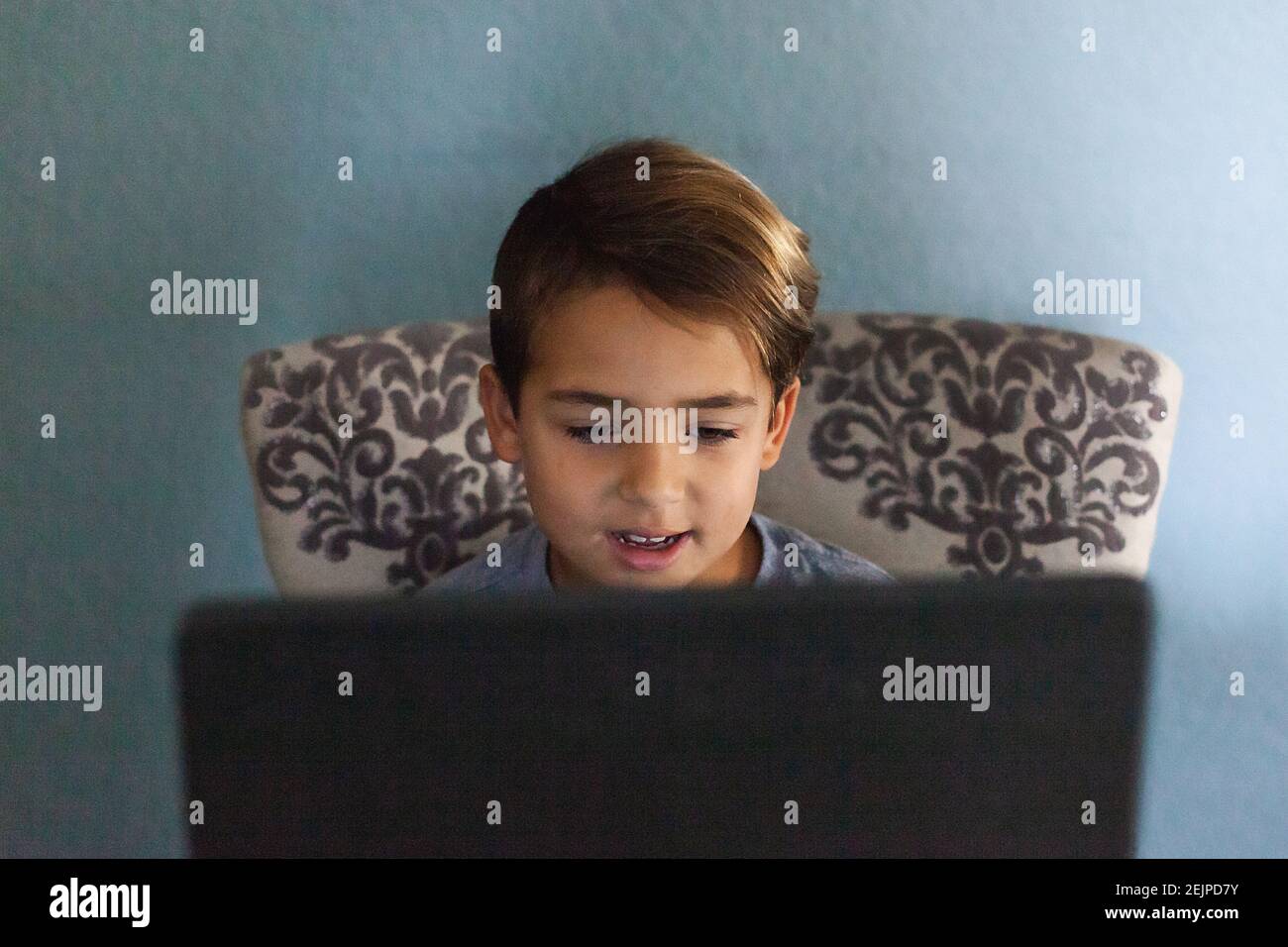 Boy doing school work on his laptop Stock Photo - Alamy
