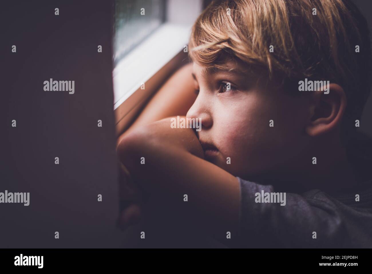 Boy with hazel eyes looking out the window Stock Photo - Alamy