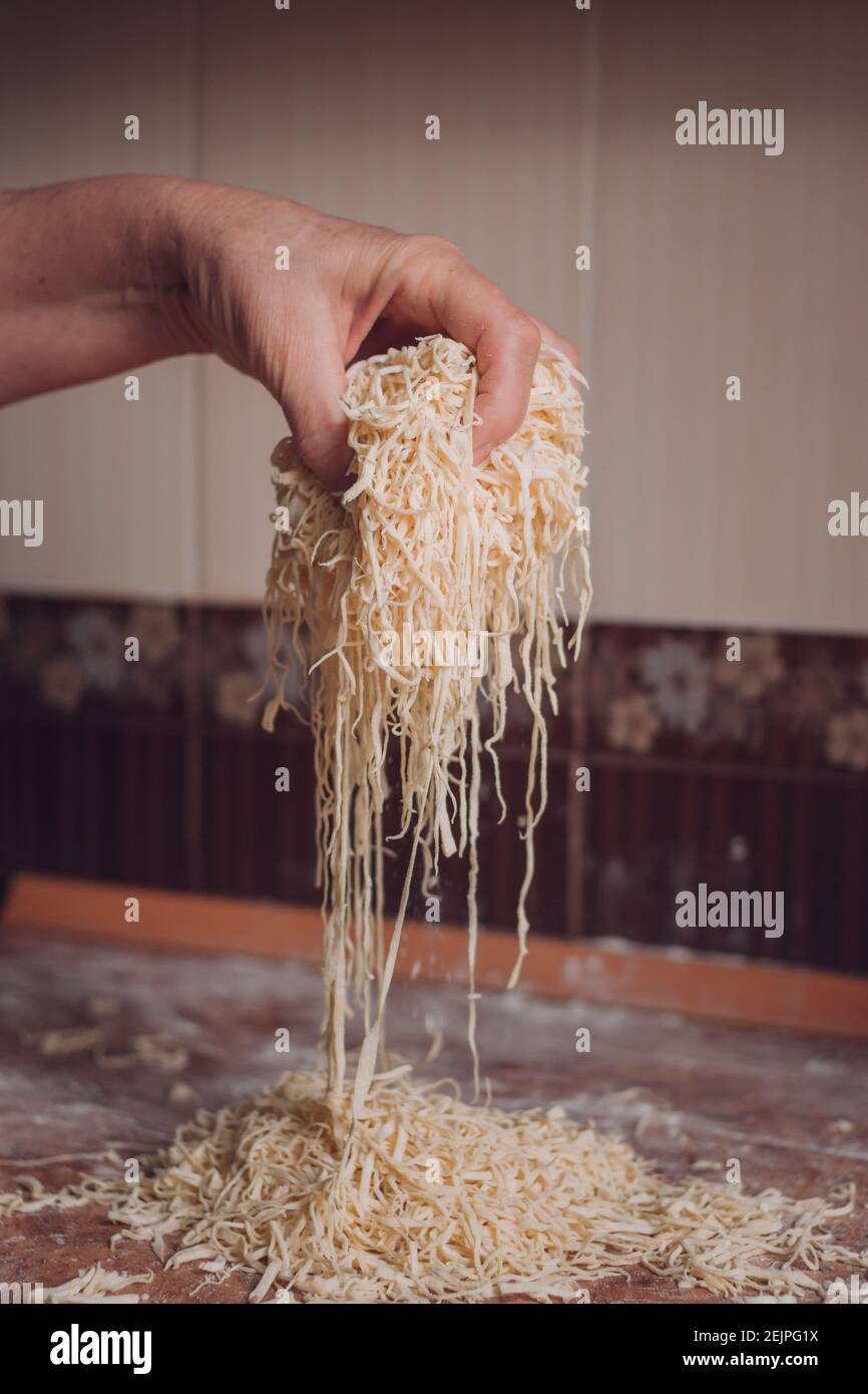 Tangled spaghetti on brown table with flour Stock Photo - Alamy
