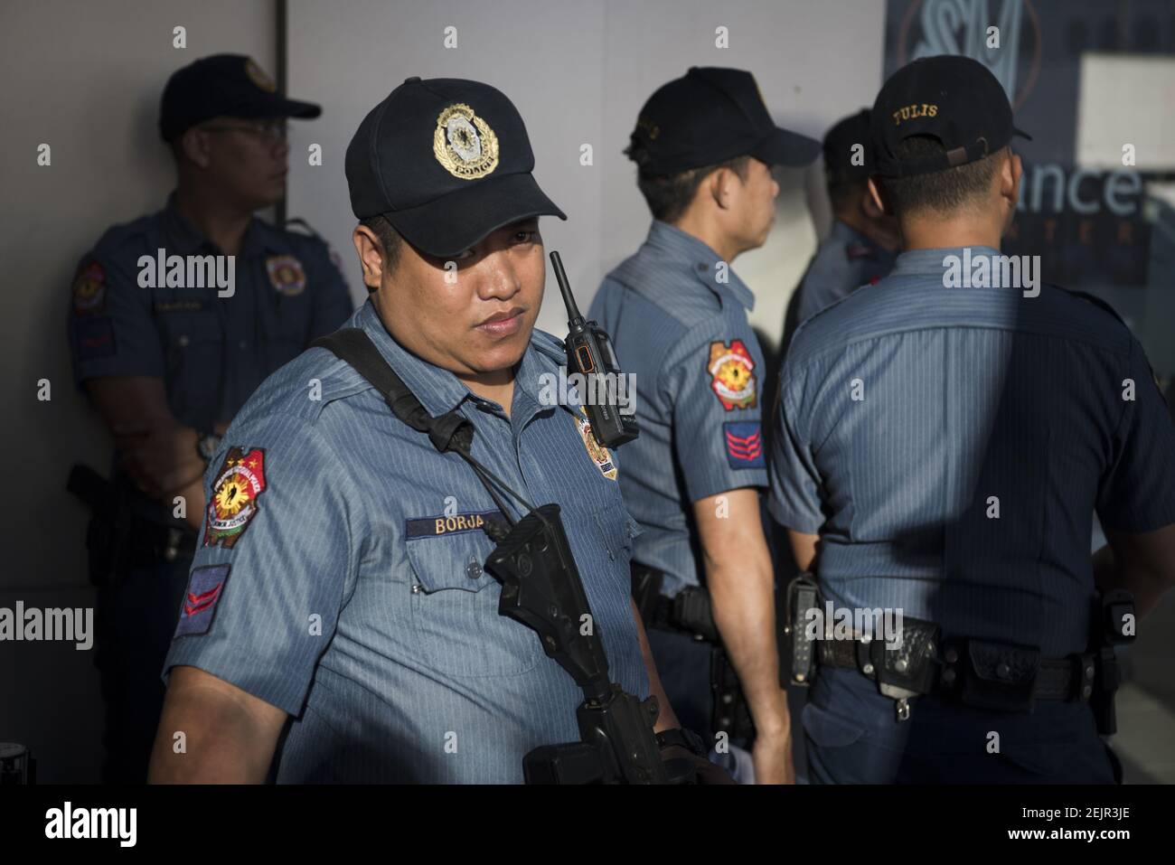 Police officers stand alert outside V shopping Mall in Manila. Police ...