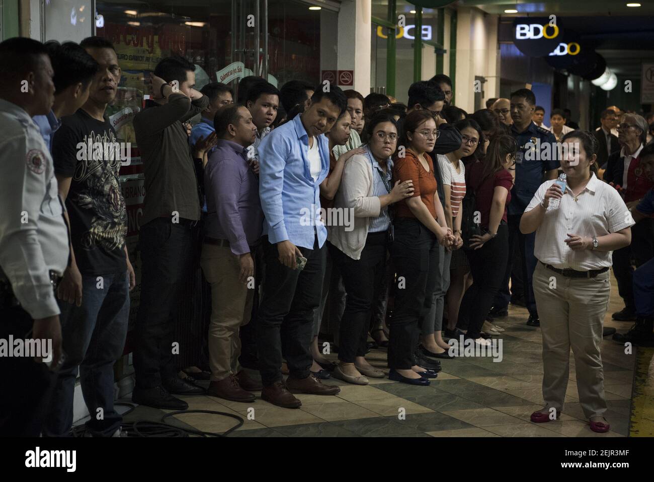 Freed hostages stand outside V shopping mall. Police surrounded a shopping mall in the ...