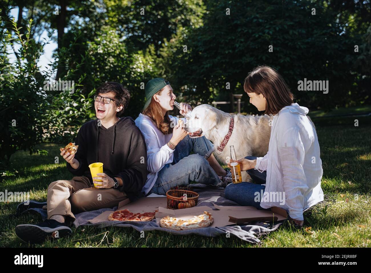 Company of beautiful young people and dog having an outdoor lunch Stock ...