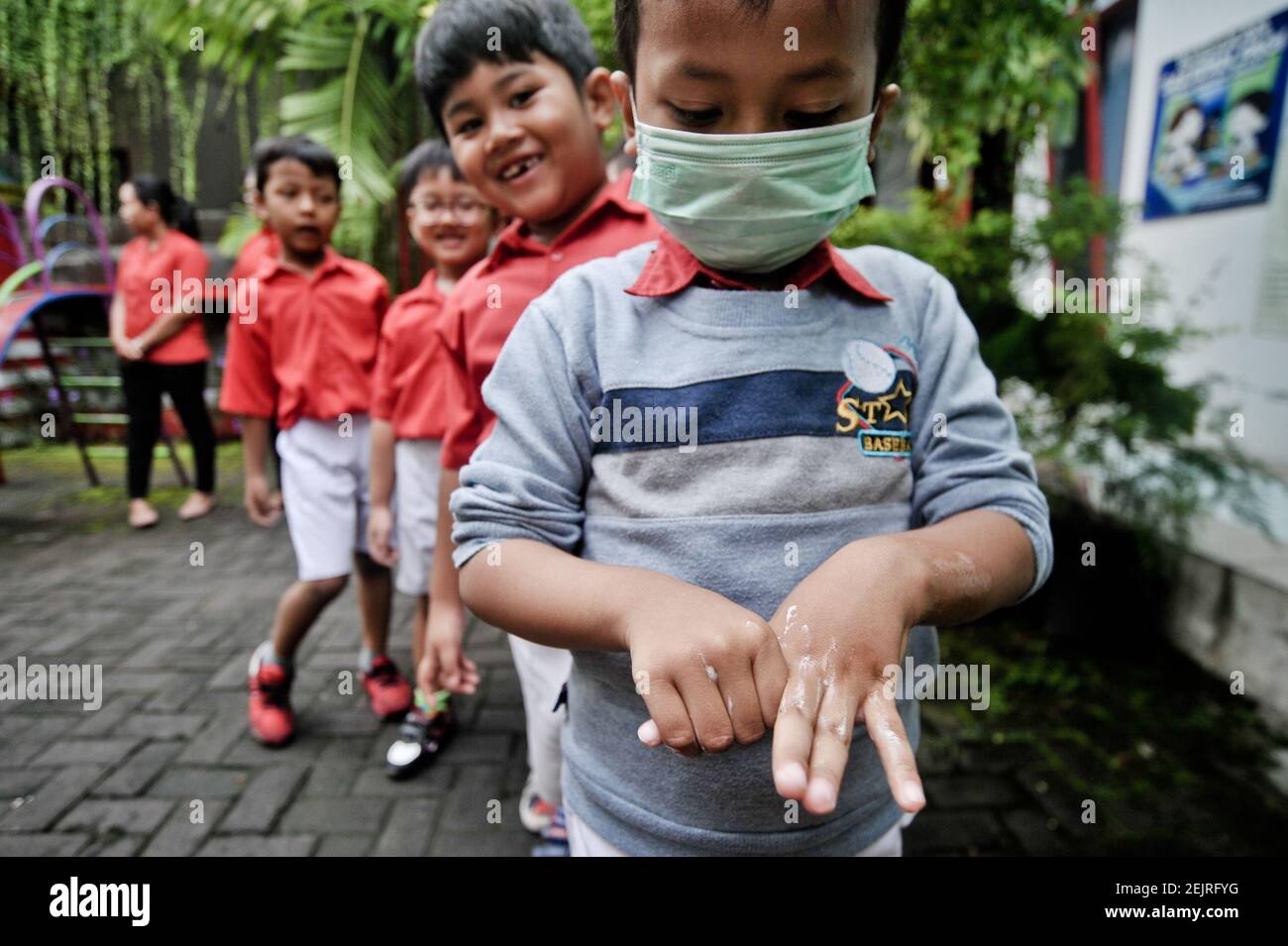 Kindergarten students attend a hand washing training session using soap ...