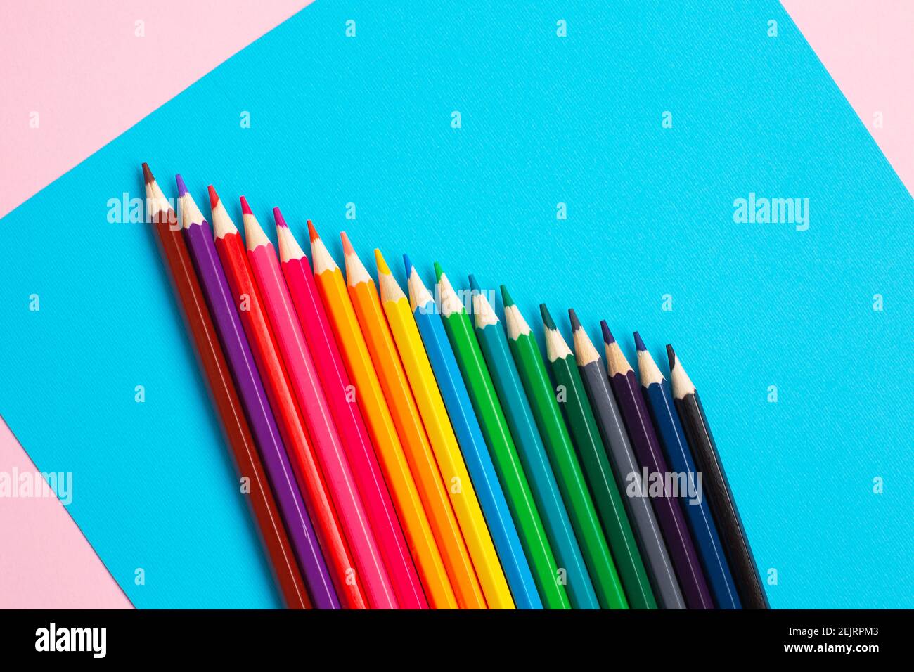 Color pencils on blue and pink background. School and office ...