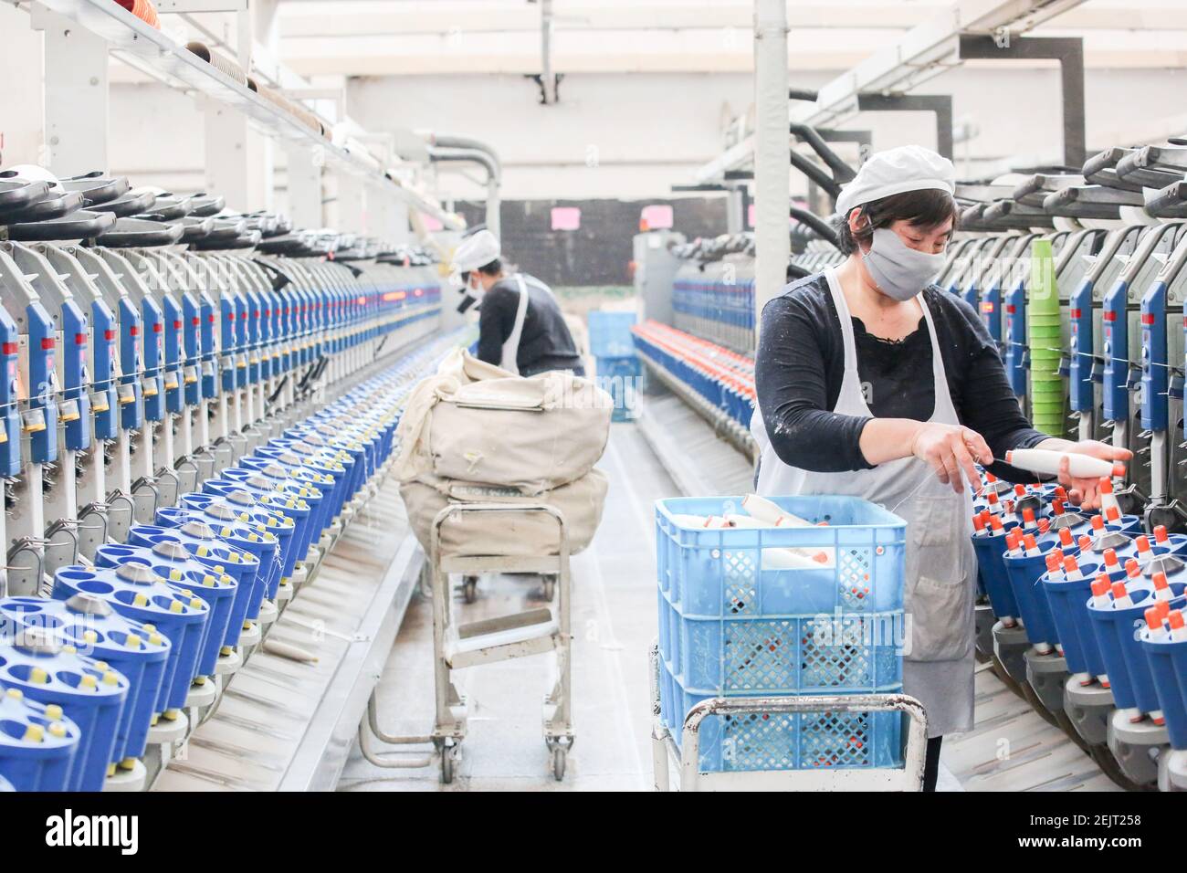 Chinese workers handle production of yarn at a textile factory in ...