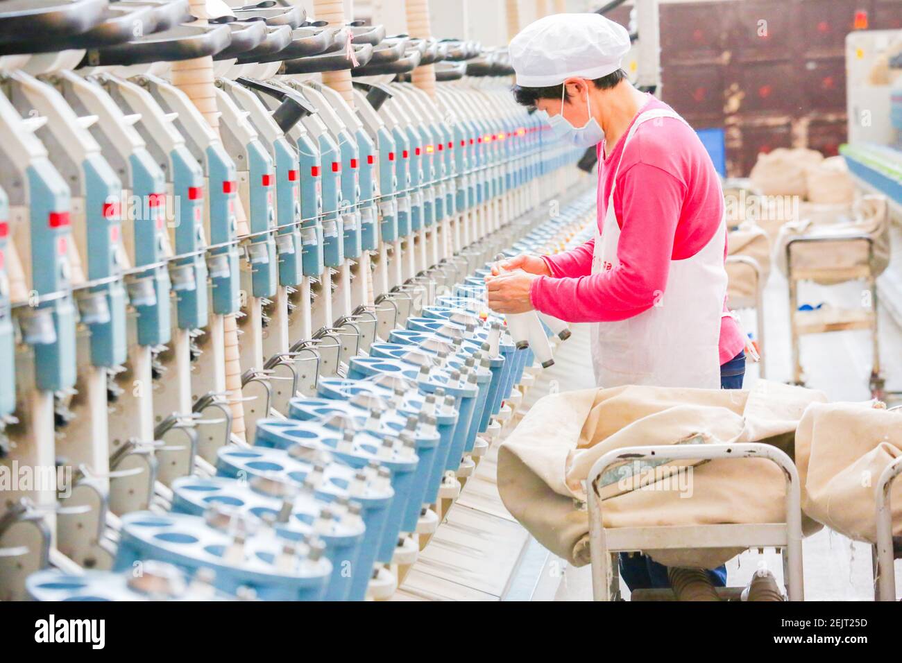 A Chinese worker handles production of yarn at a textile factory in ...