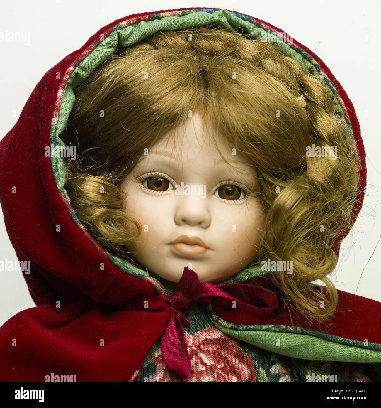 Closeup shot of a vintage doll with a beautiful red mantle and golden ...