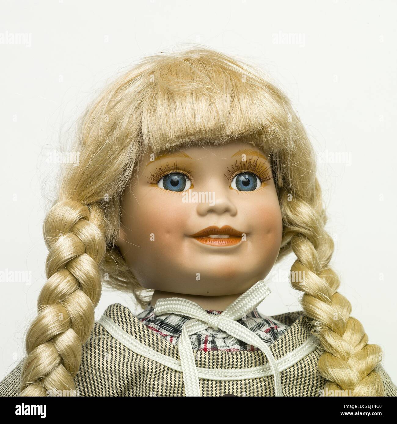 Closeup shot of a vintage doll with golden braids on the white ...