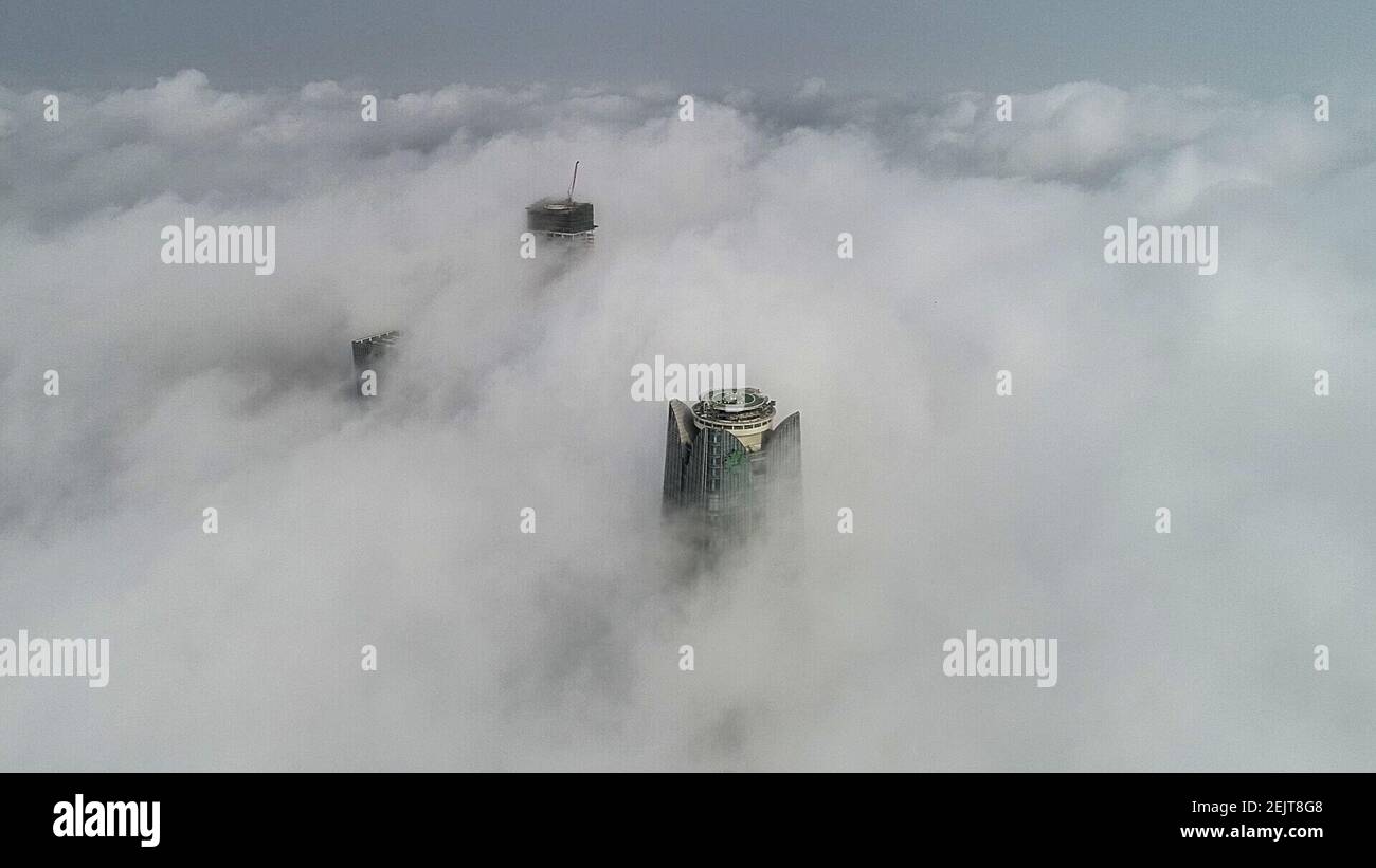 An aerial view of the skyscrappers enveloped by fog in Nanning city ...