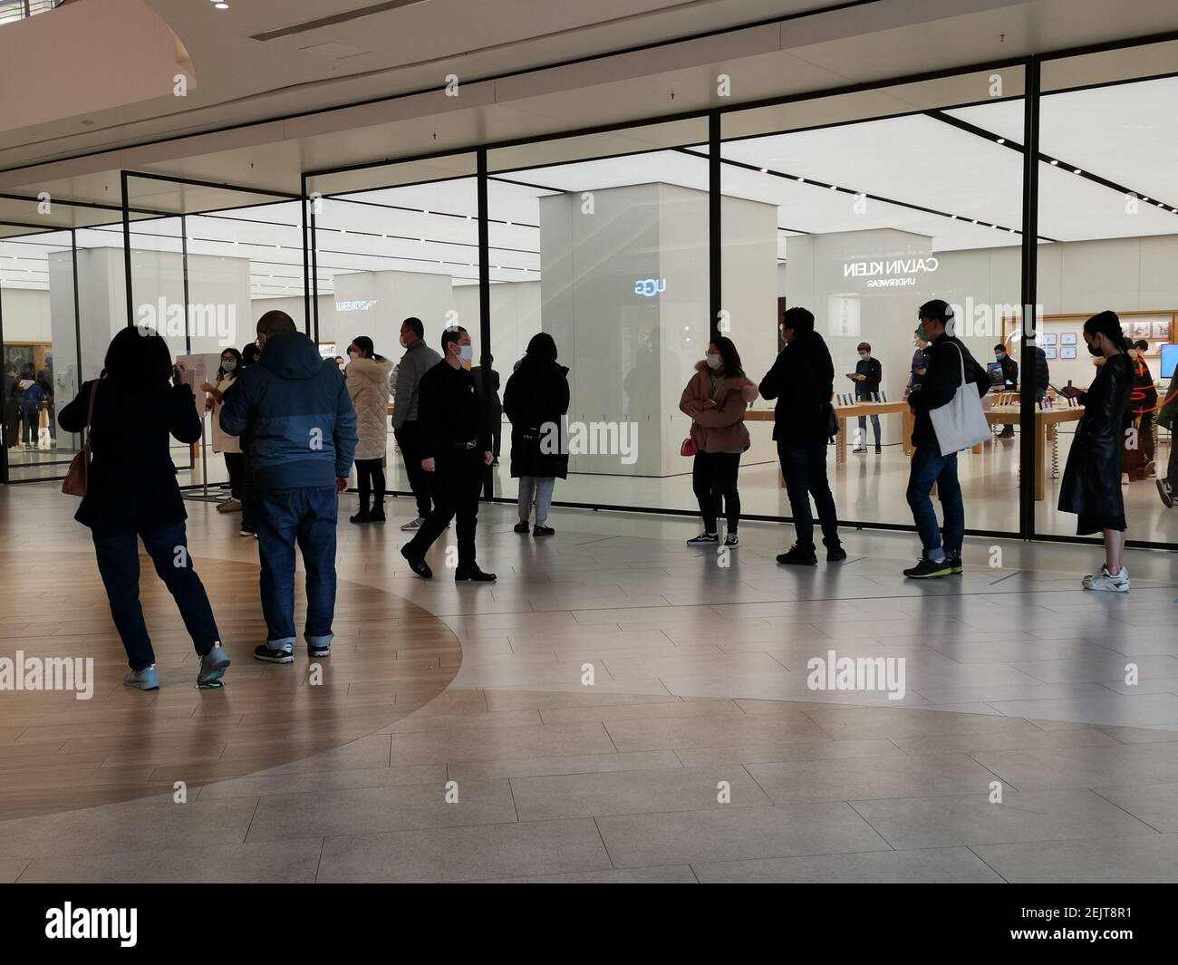 People line up outside a shopping mall to get inside in Qibao district ...
