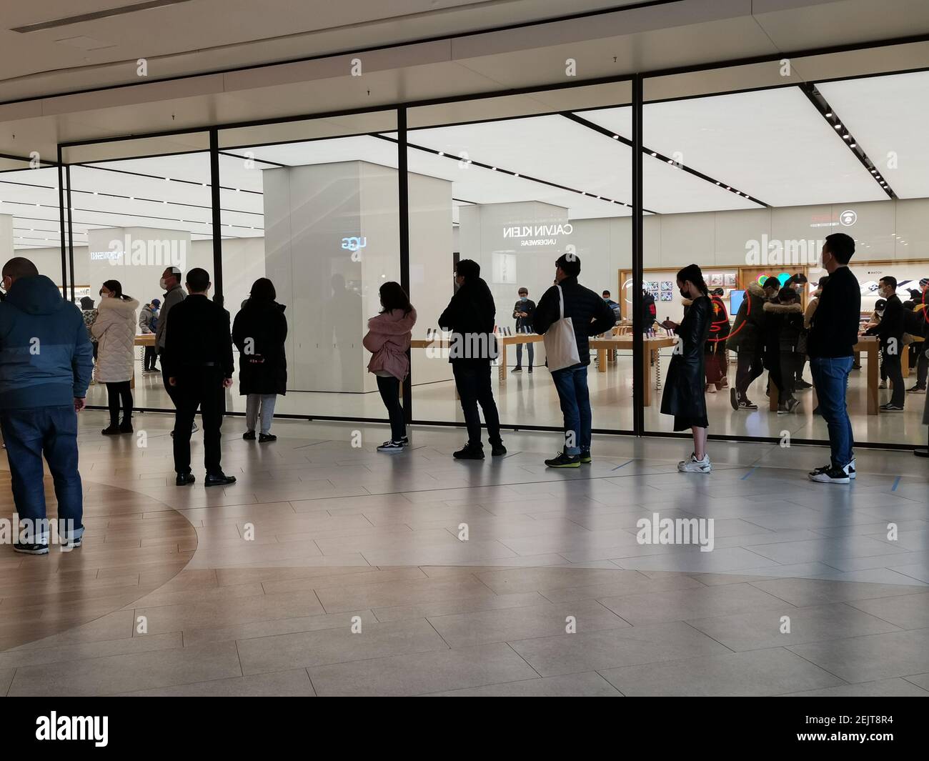 People line up outside a shopping mall to get inside in Qibao district ...