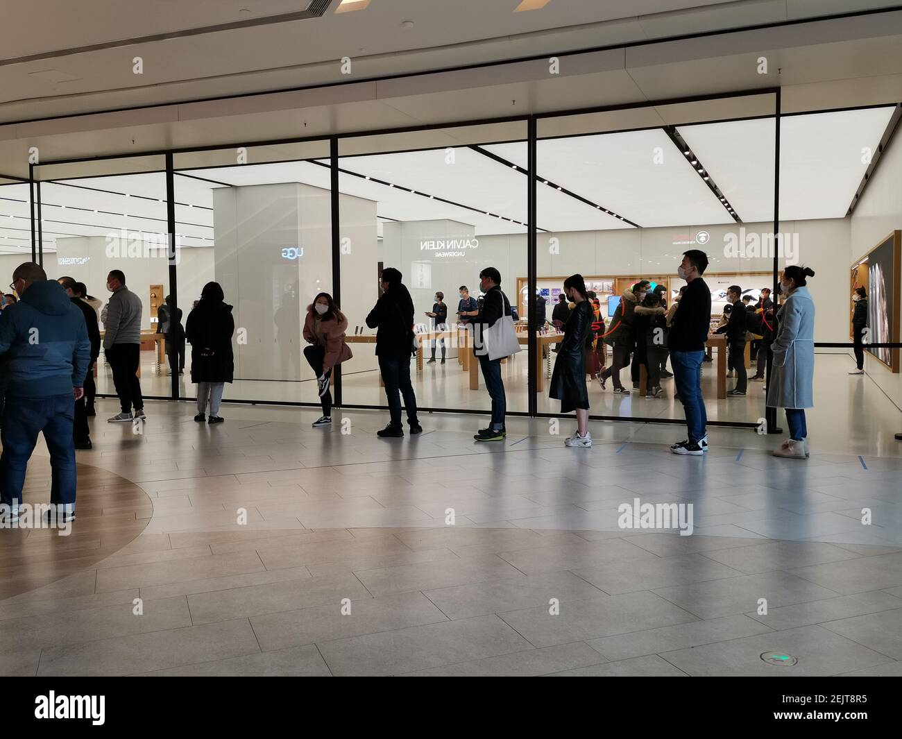 People line up outside a shopping mall to get inside in Qibao district ...