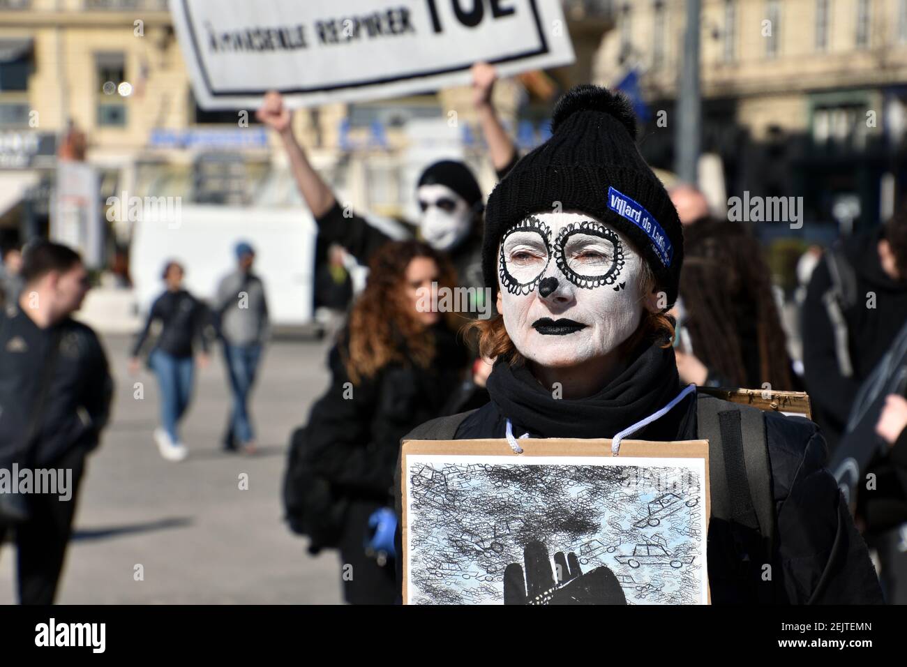 A masked protester holding a placard during the demonstration. The ...