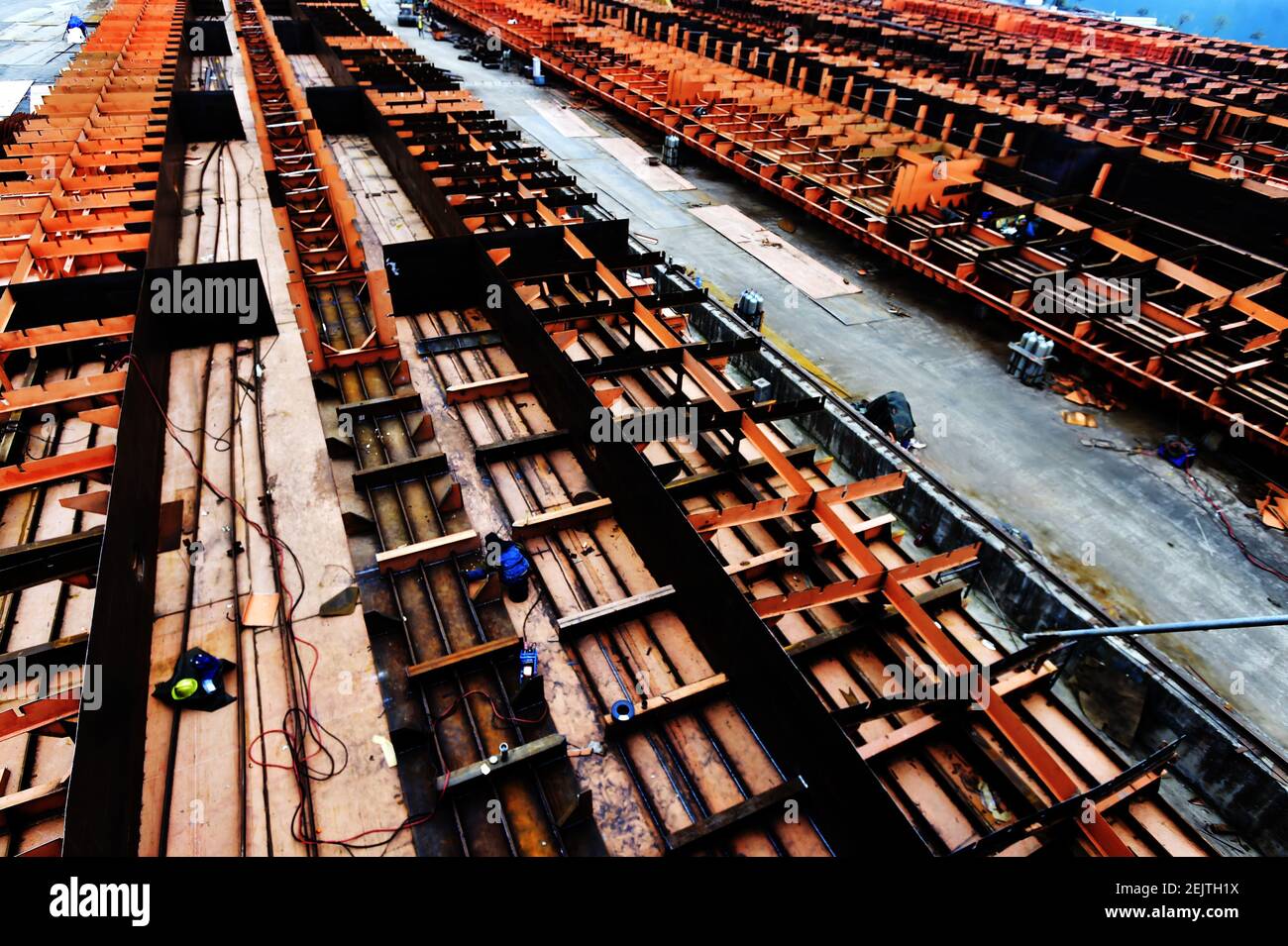 Staff work to produce a large vessel at a ship factory along the ...