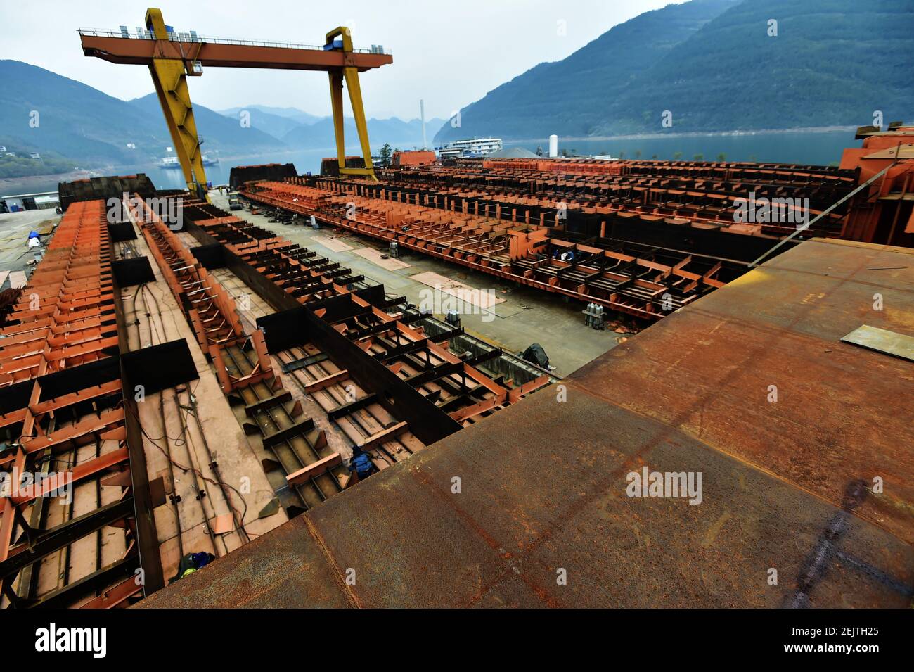 Staff work to produce a large vessel at a ship factory along the ...
