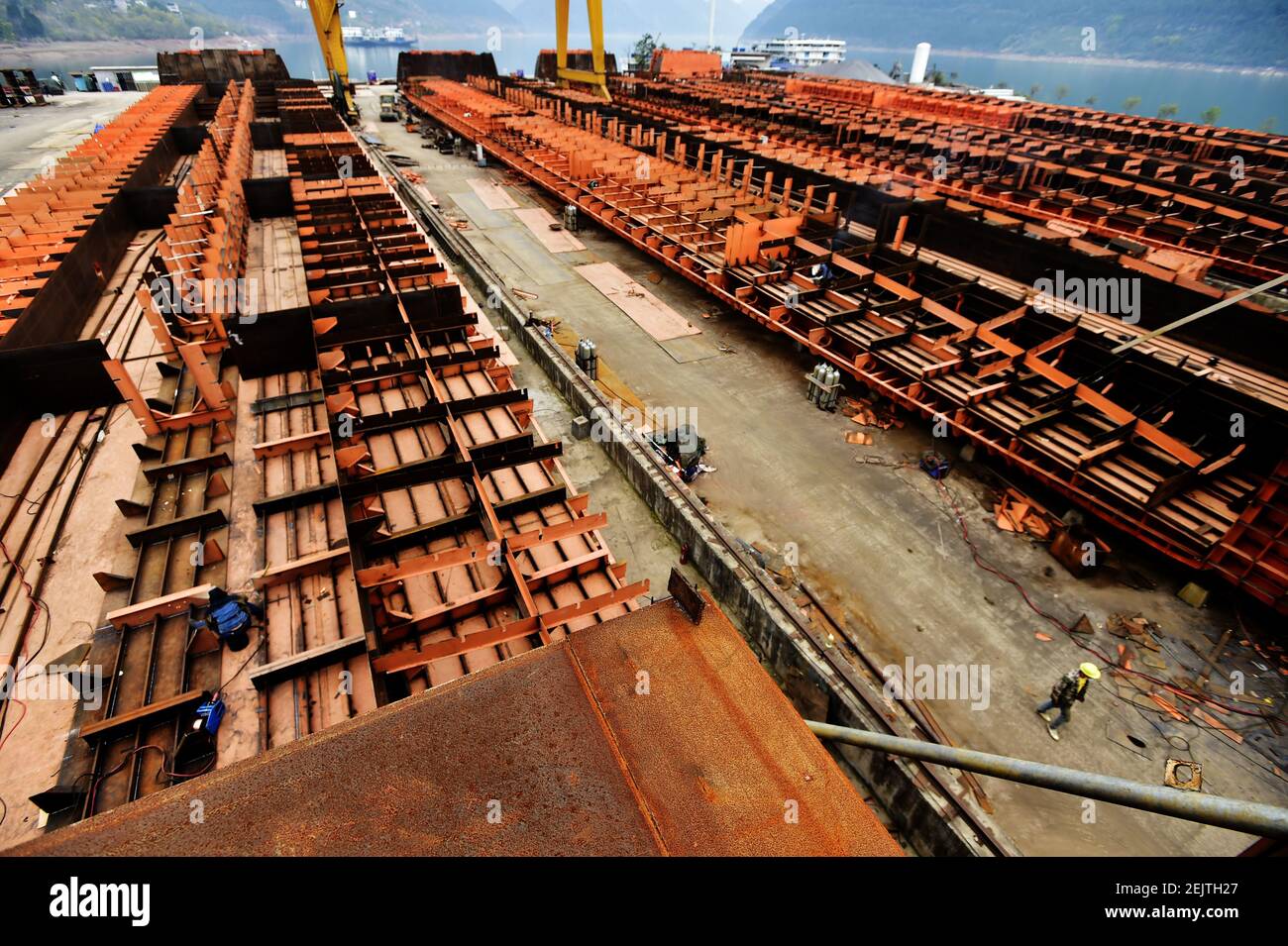 Staff work to produce a large vessel at a ship factory along the ...