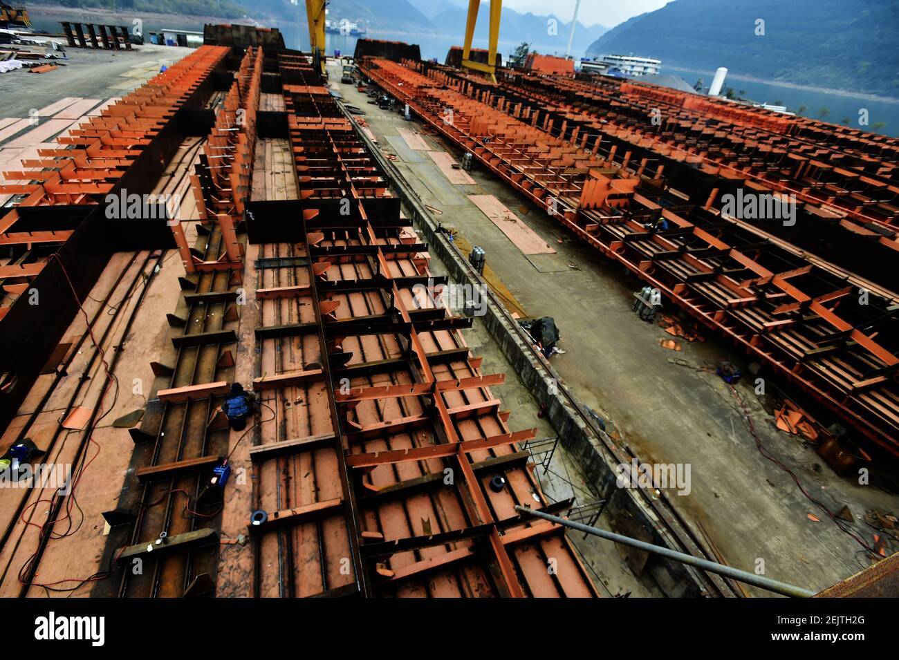 Staff work to produce a large vessel at a ship factory along the ...