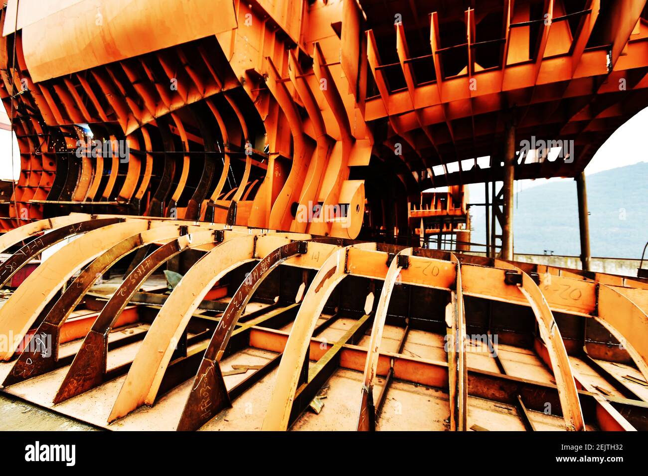 Staff work to produce a large vessel at a ship factory along the ...