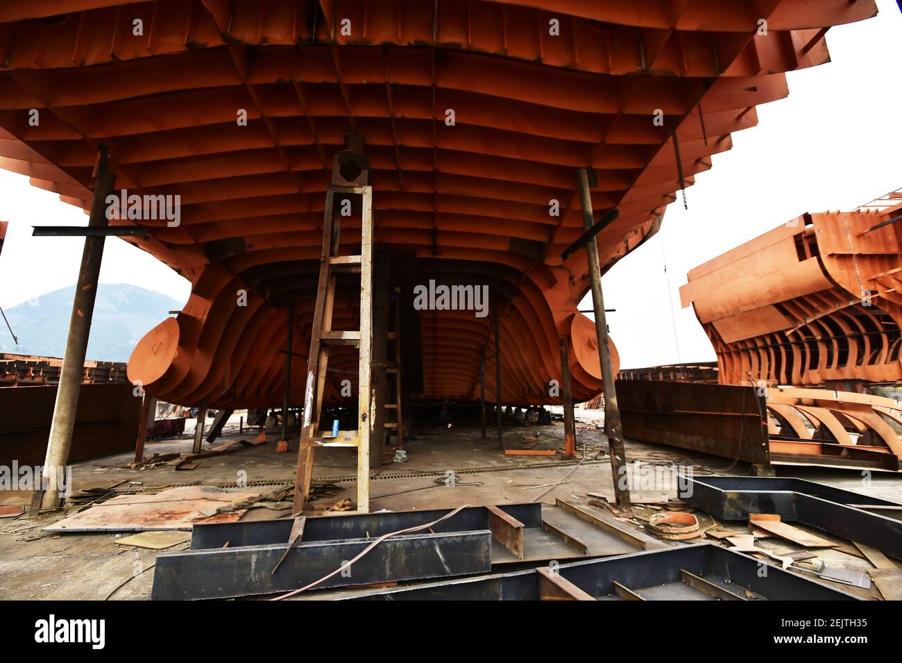Staff work to produce a large vessel at a ship factory along the ...