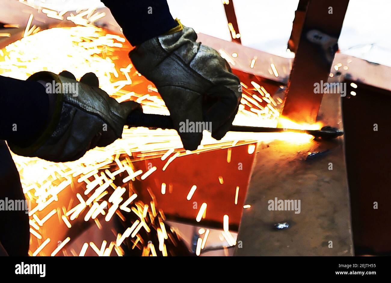 Staff work to produce a large vessel at a ship factory along the ...