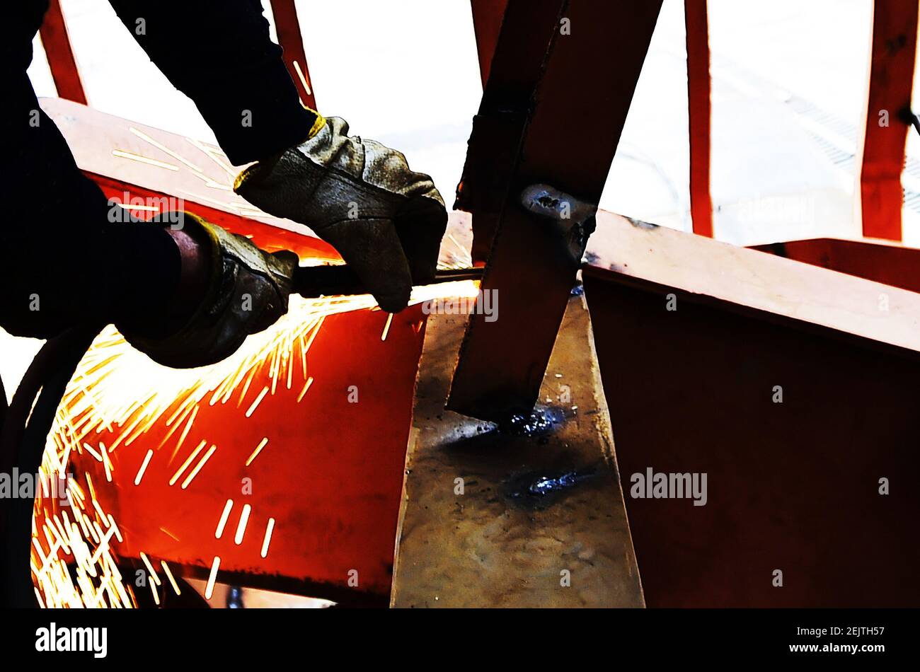 Staff work to produce a large vessel at a ship factory along the ...