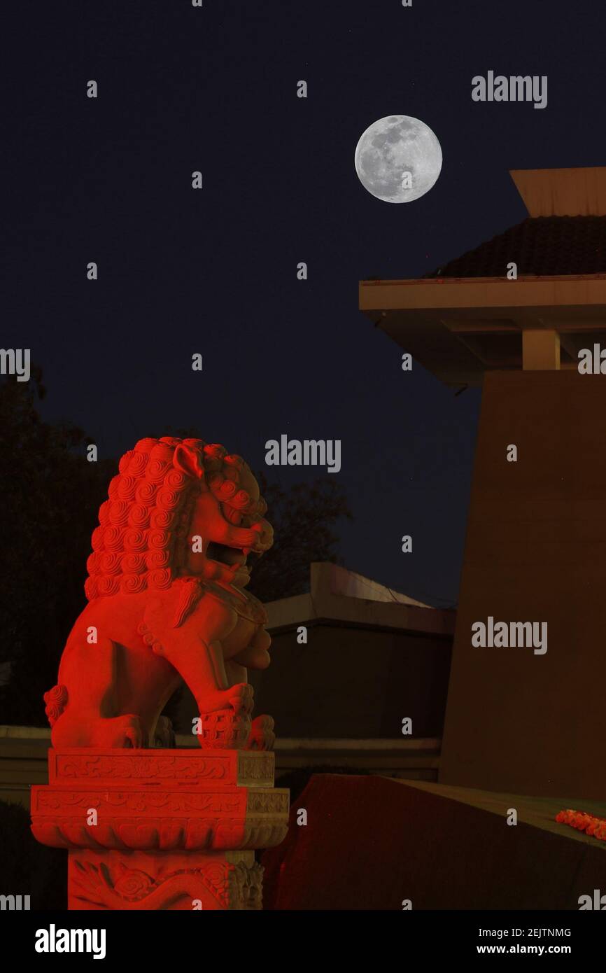 A photo of double exposure: A super moon appears above a Chinese ...