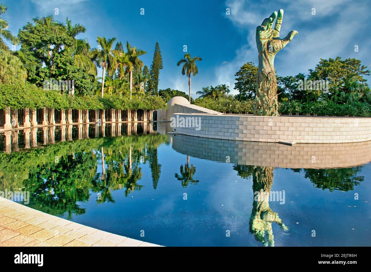An outstretched arm reaches to the sky in the reflection pool of the ...