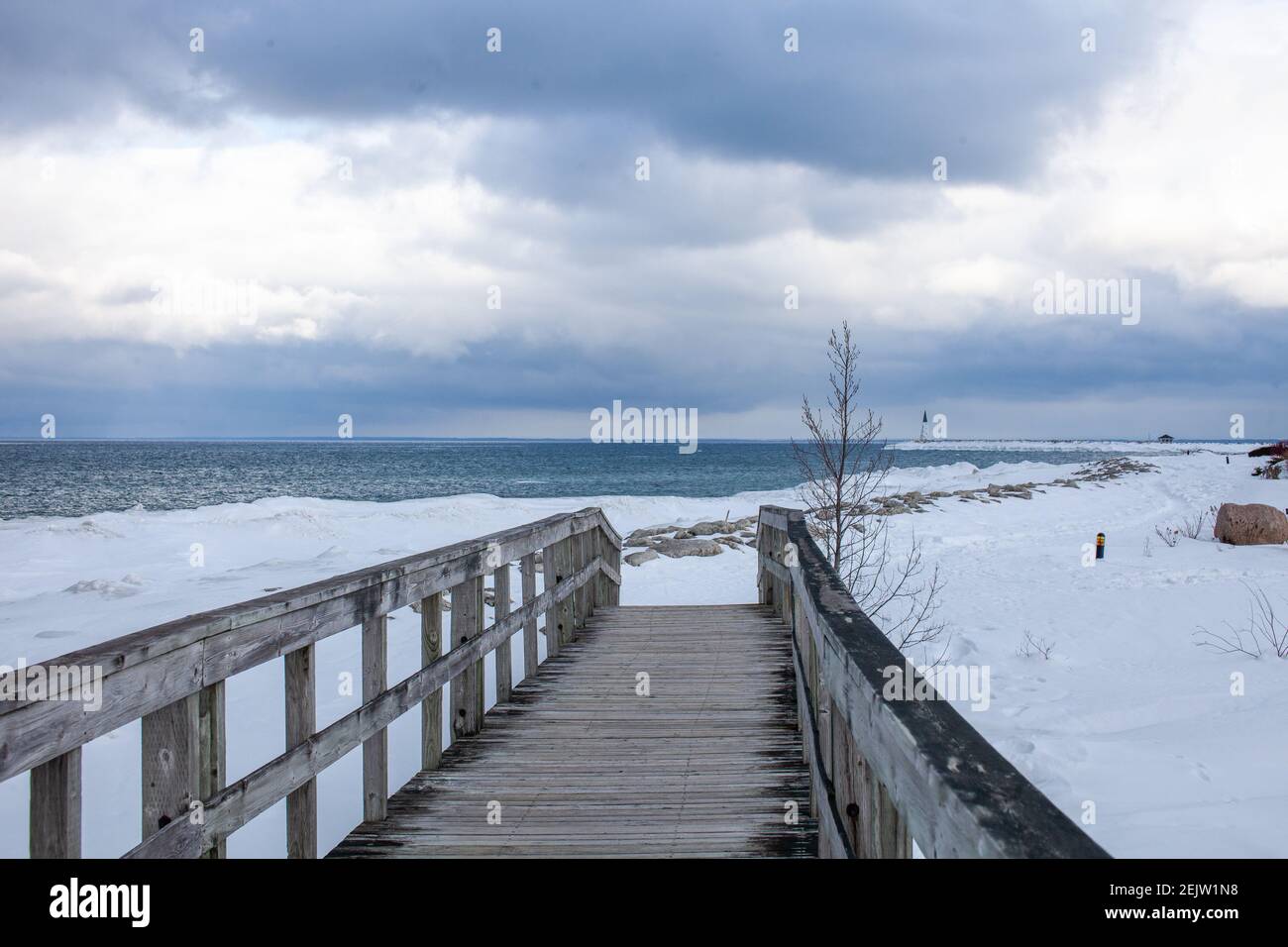 An old, wooden bridge crosses a section of frozen Georgian Bay ...