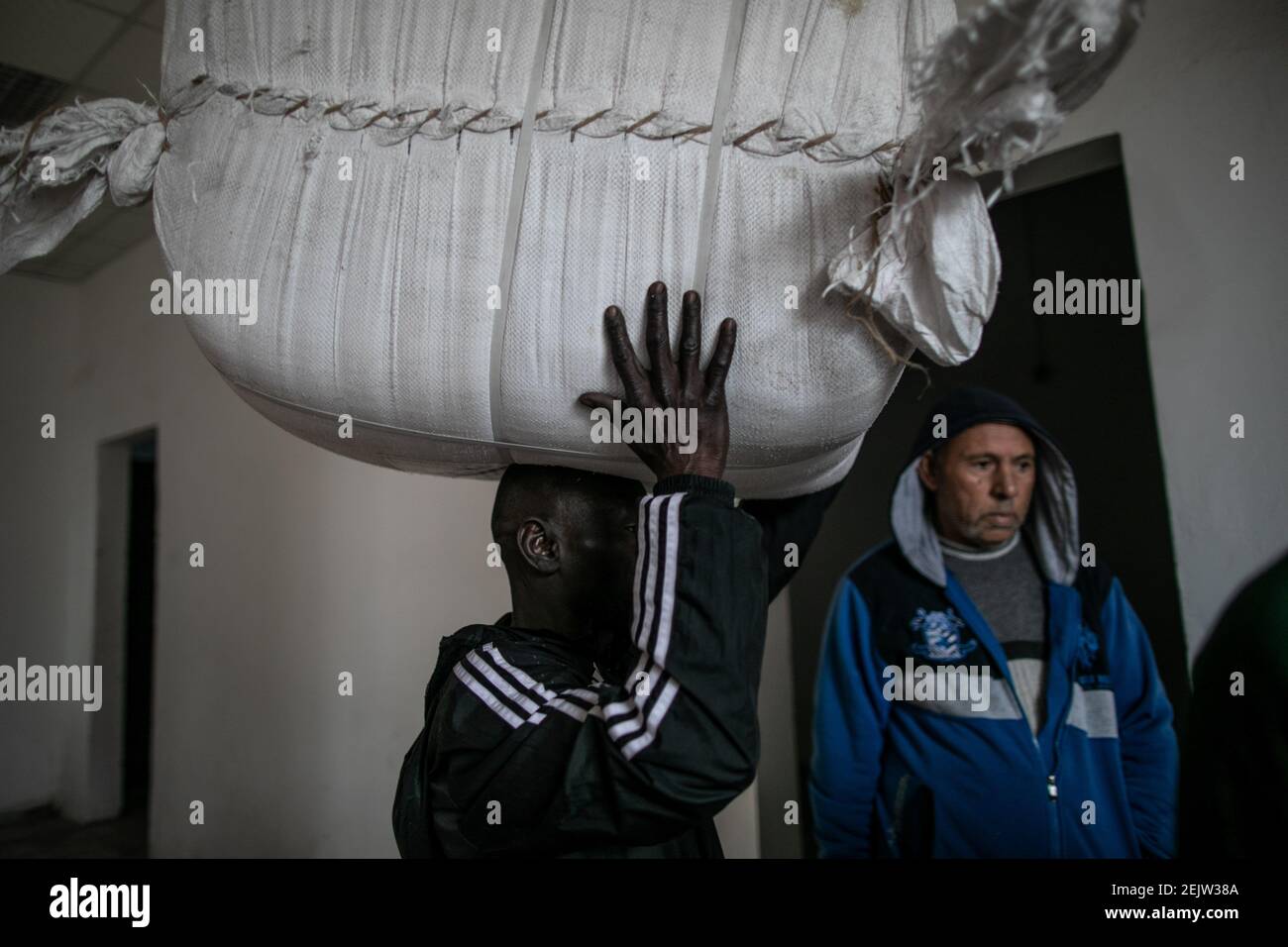 TRIPOLI, Mar. 10, 2020 -- A displaced man carries International Red ...