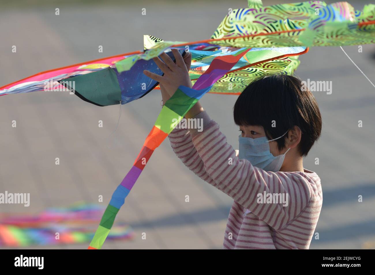 A kid wears a protective mask while flying a kite amid Coronavirus ...