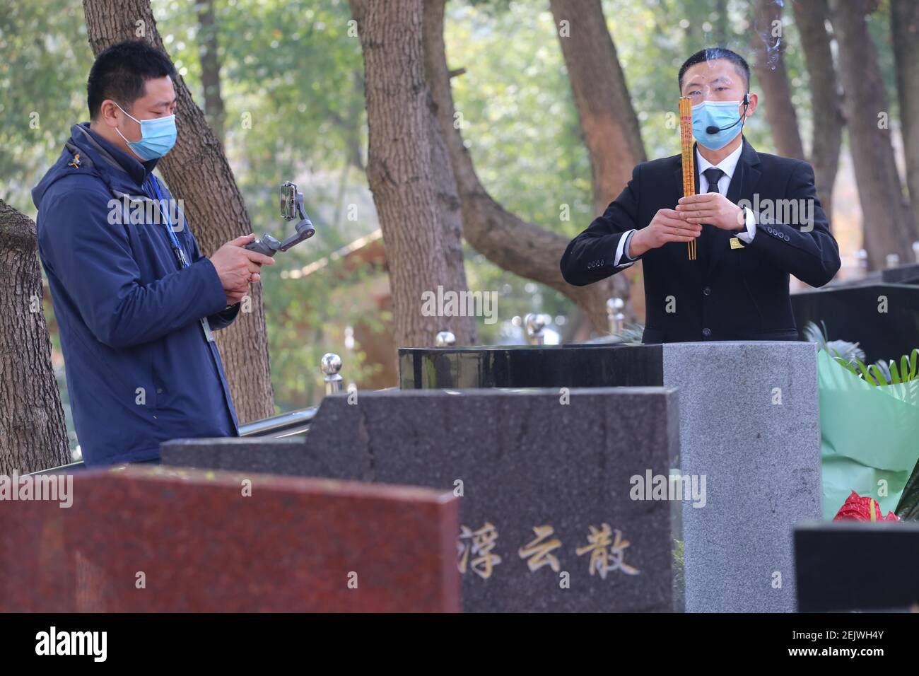 A staff of a local cemetery does online tomb sweeping and worshiping to ...