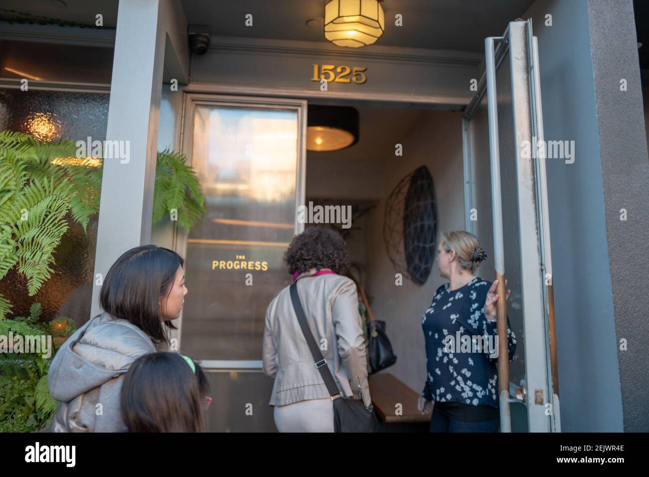 People line up to enter The Progress, an iconic Michelin starred restaurant in the Fillmore ...