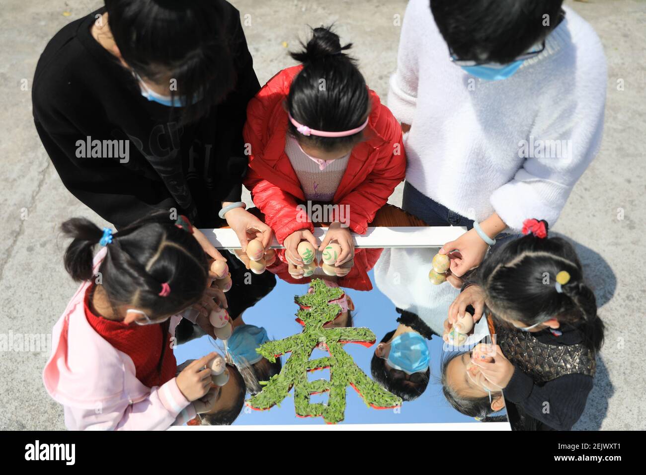 Childrens are playing egg standing game to welcome traditional festival ...
