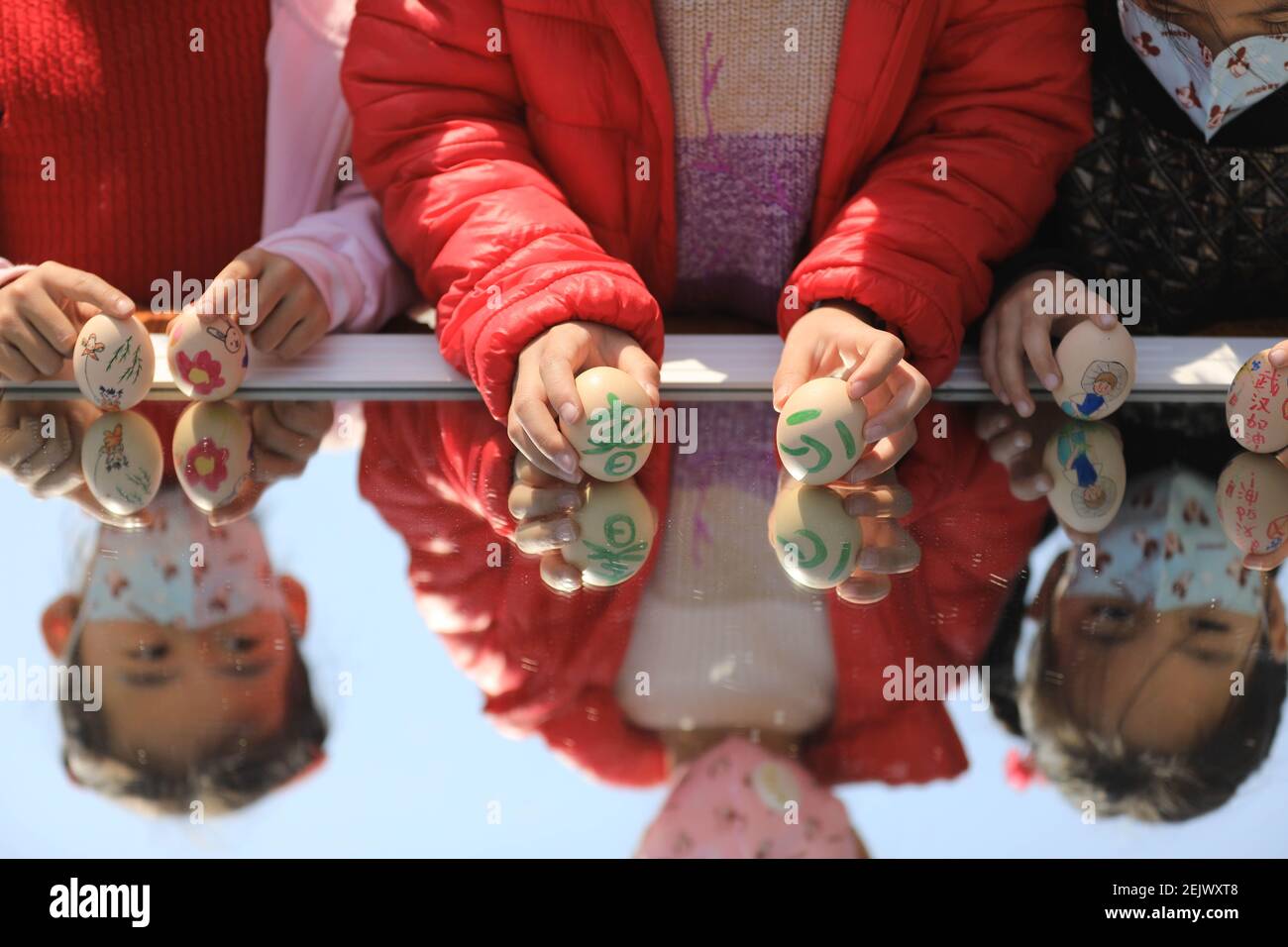 Childrens are playing egg standing game to welcome traditional festival ...