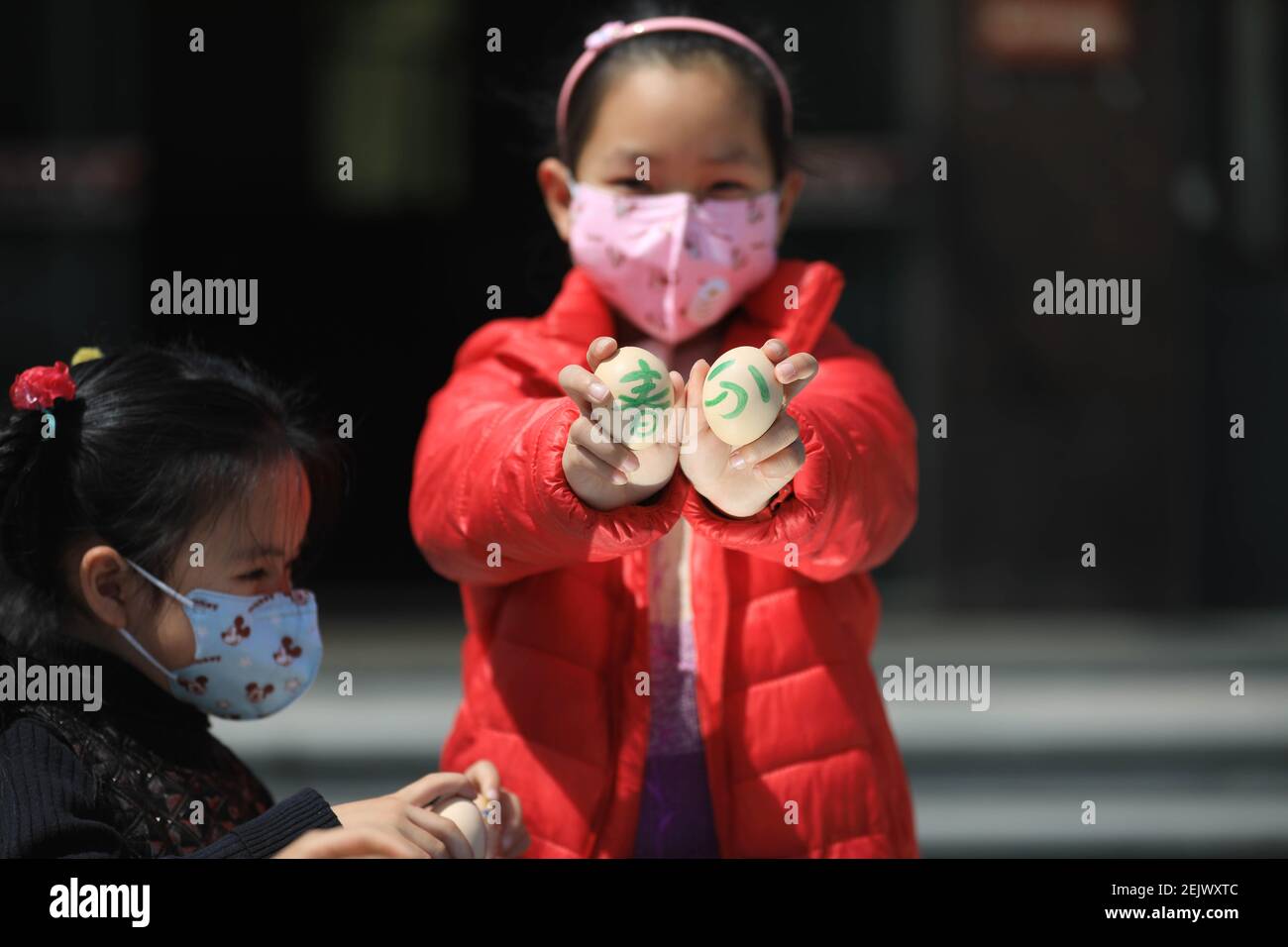 Childrens are playing egg standing game to welcome traditional festival ...