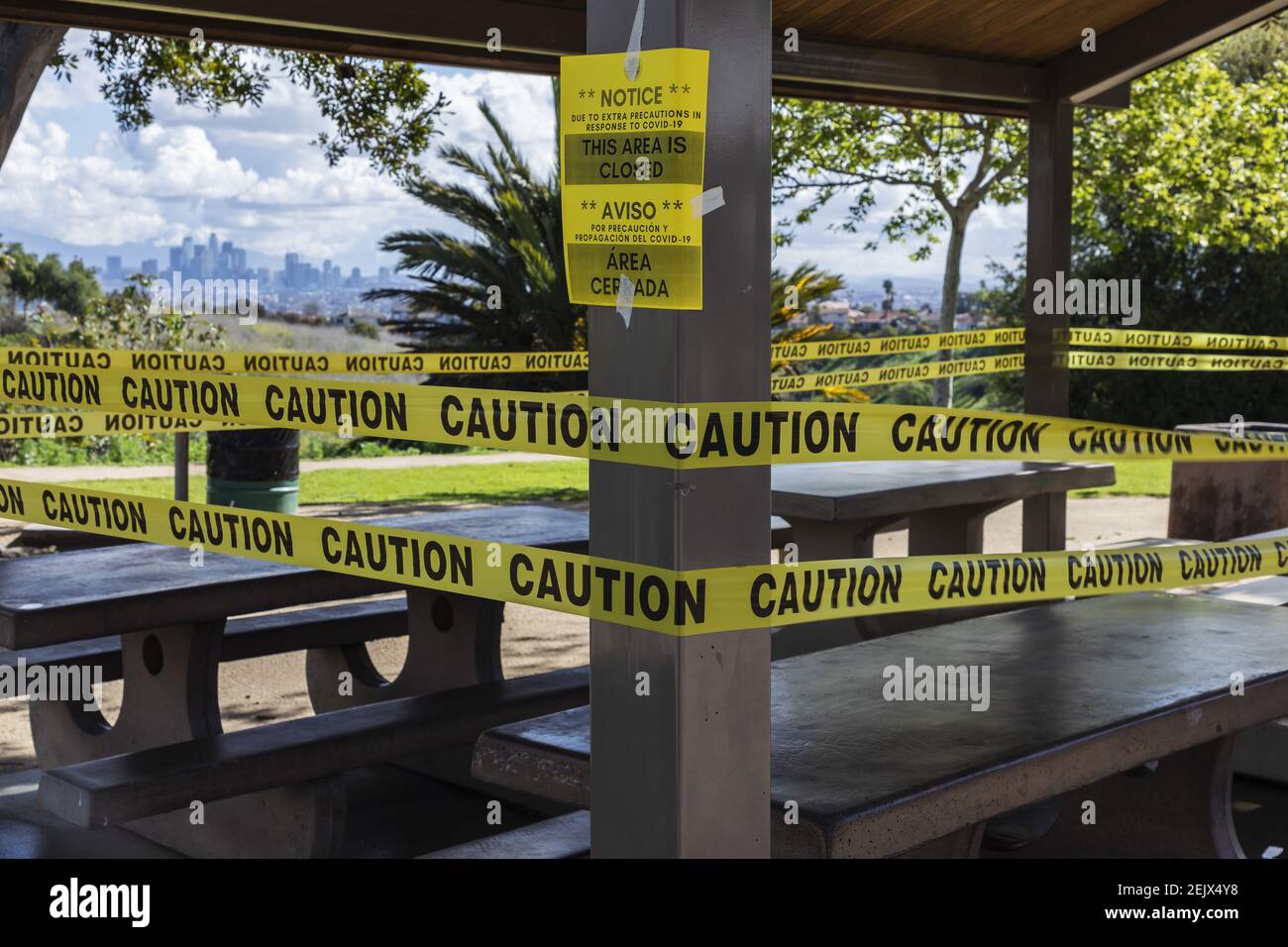 Park benches with yellow warning tape and a notice of closure. Parks ...