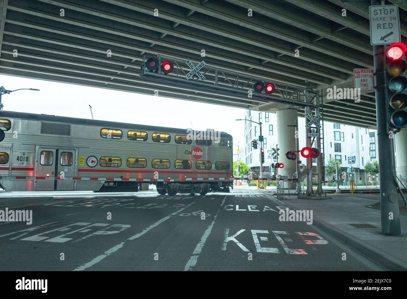 A nearly empty Caltrain train passes through a level crossing during an ...