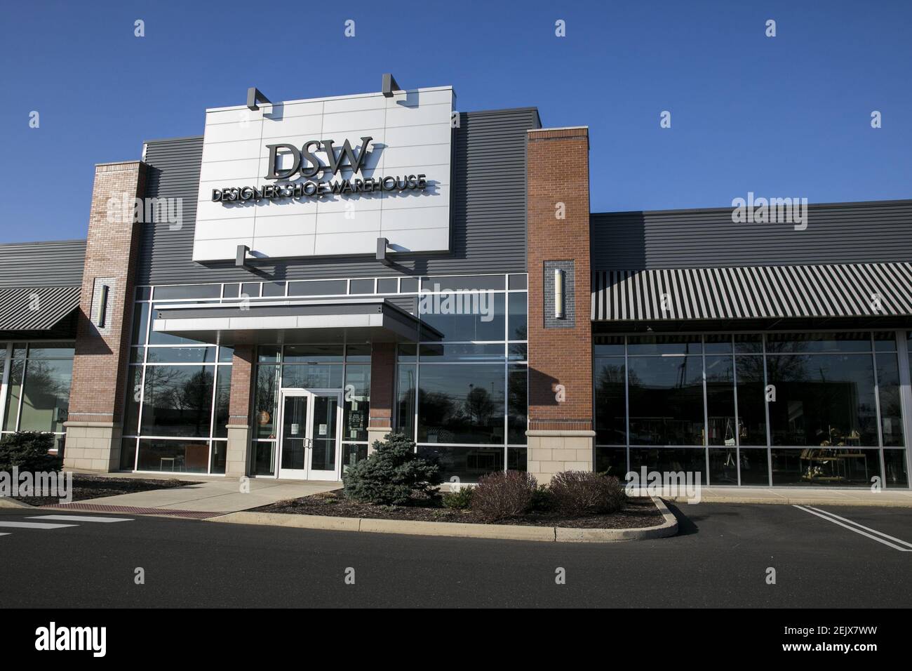 A logo sign outside of a Designer Shoe Warehouse (DSW) retail store ...