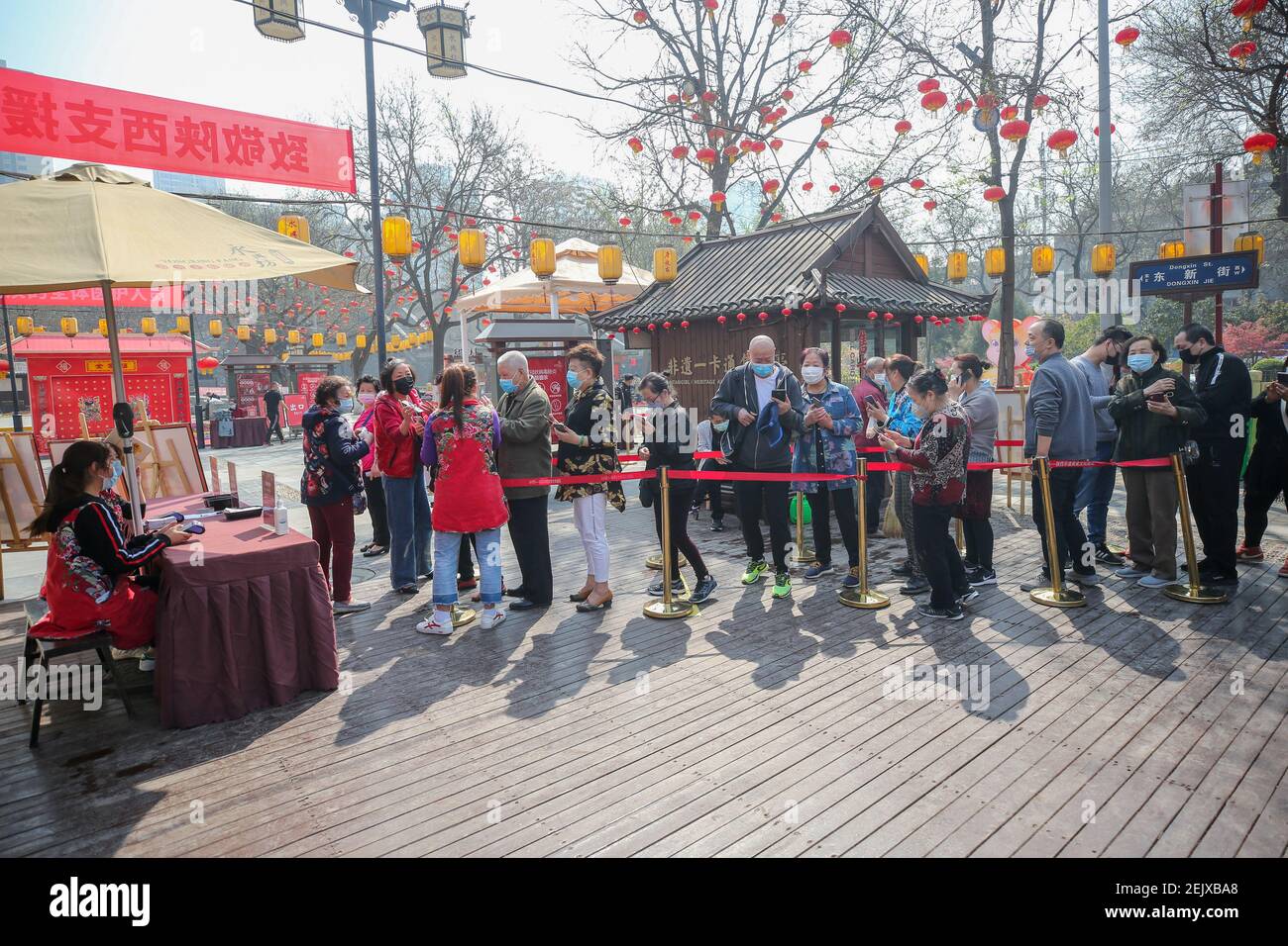 People line up to get coupons at Yongxing Fang in Xi'an city, central ...