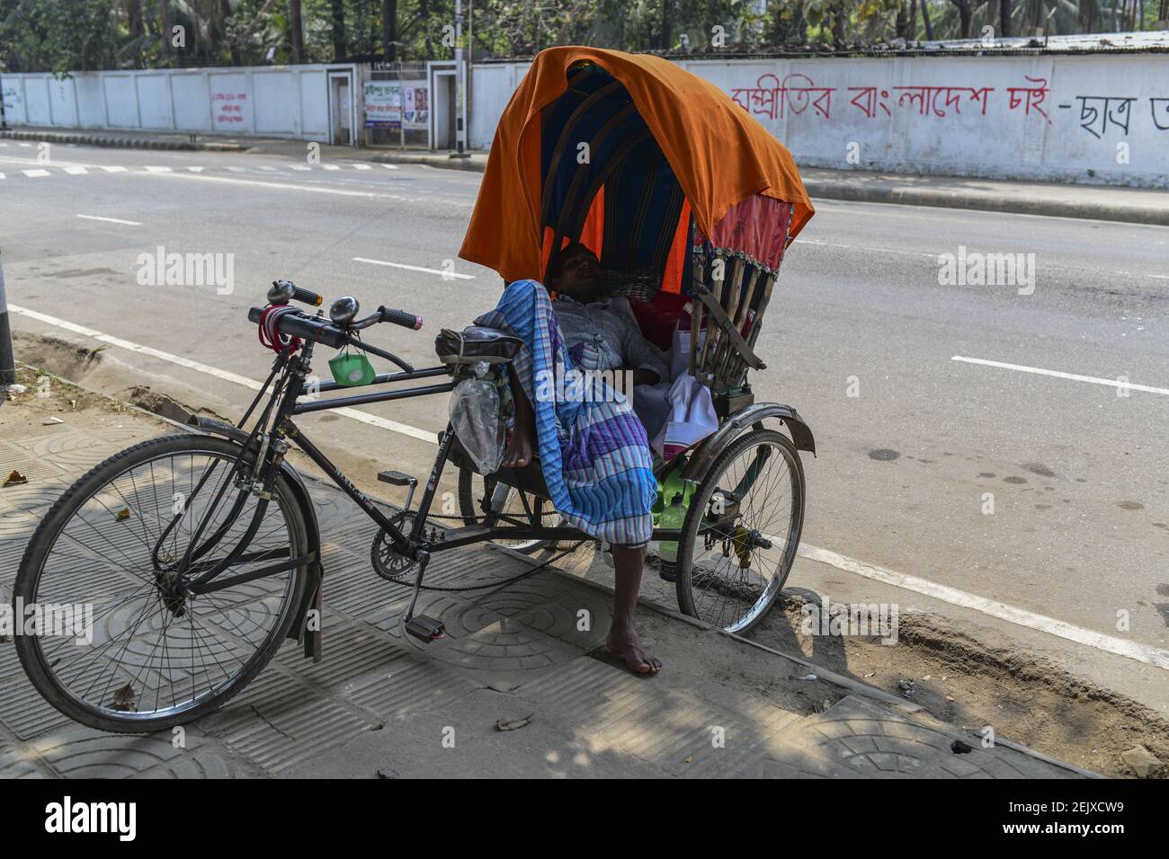 Bangladeshi Rickshaw puller sleeps on rickshaw on Dhaka University ...