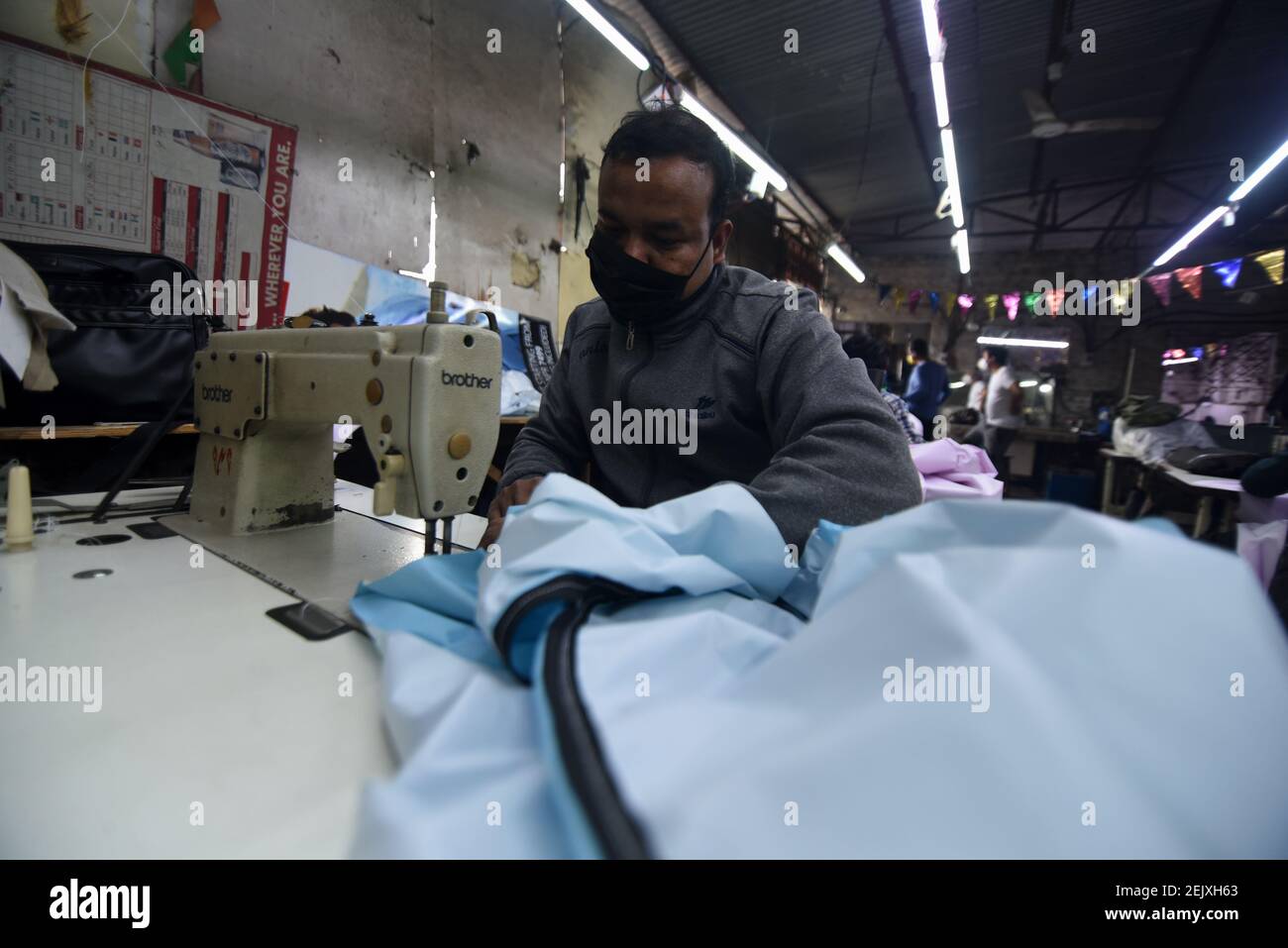 A Nepalese worker sewing Personal Protective Equipment (PPE) dress at a ...