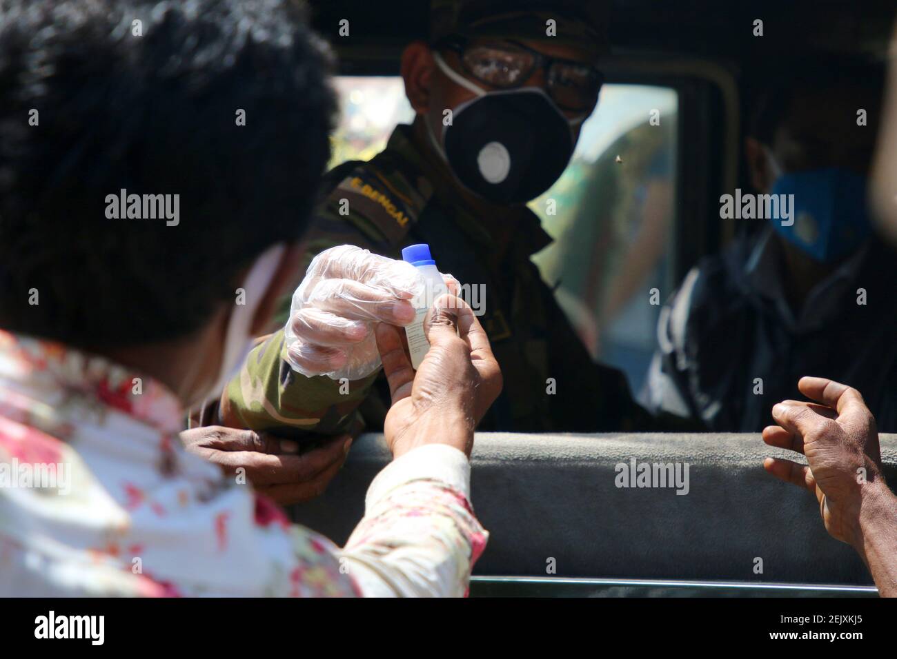 An army soldier distributes hand sanitizer to the poor people amid ...
