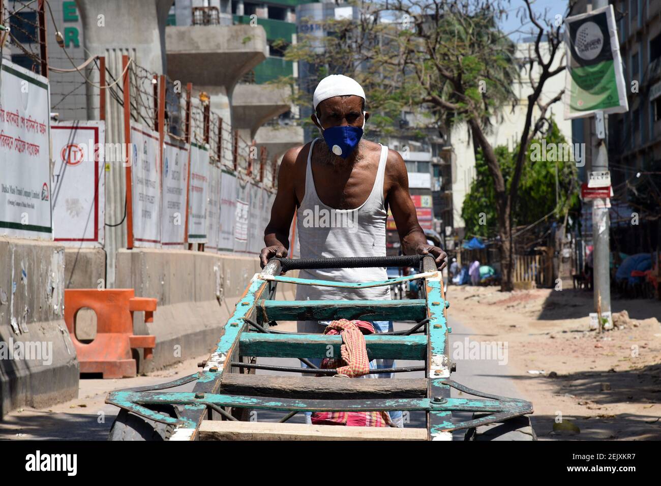 Man pulling hand cart wearing a face mask amid concerns over the spread ...