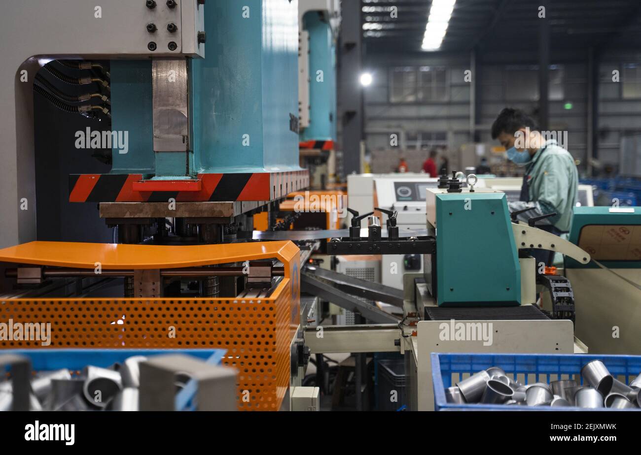 A worker is working on a stamping production line of automotive filters ...