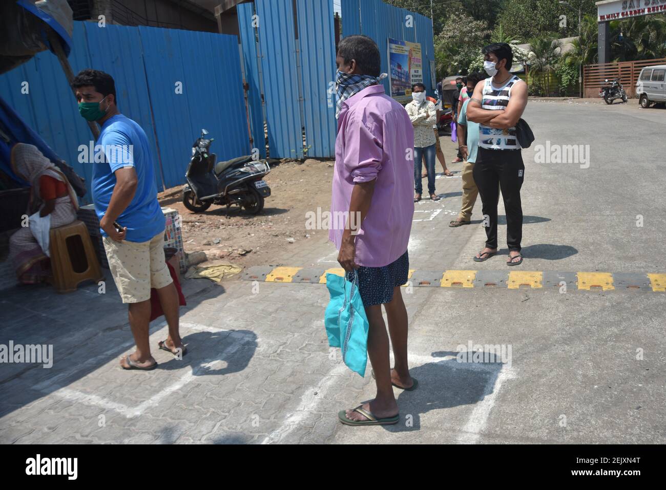 People in a queue at a food market follow distancing measures aimed at ...