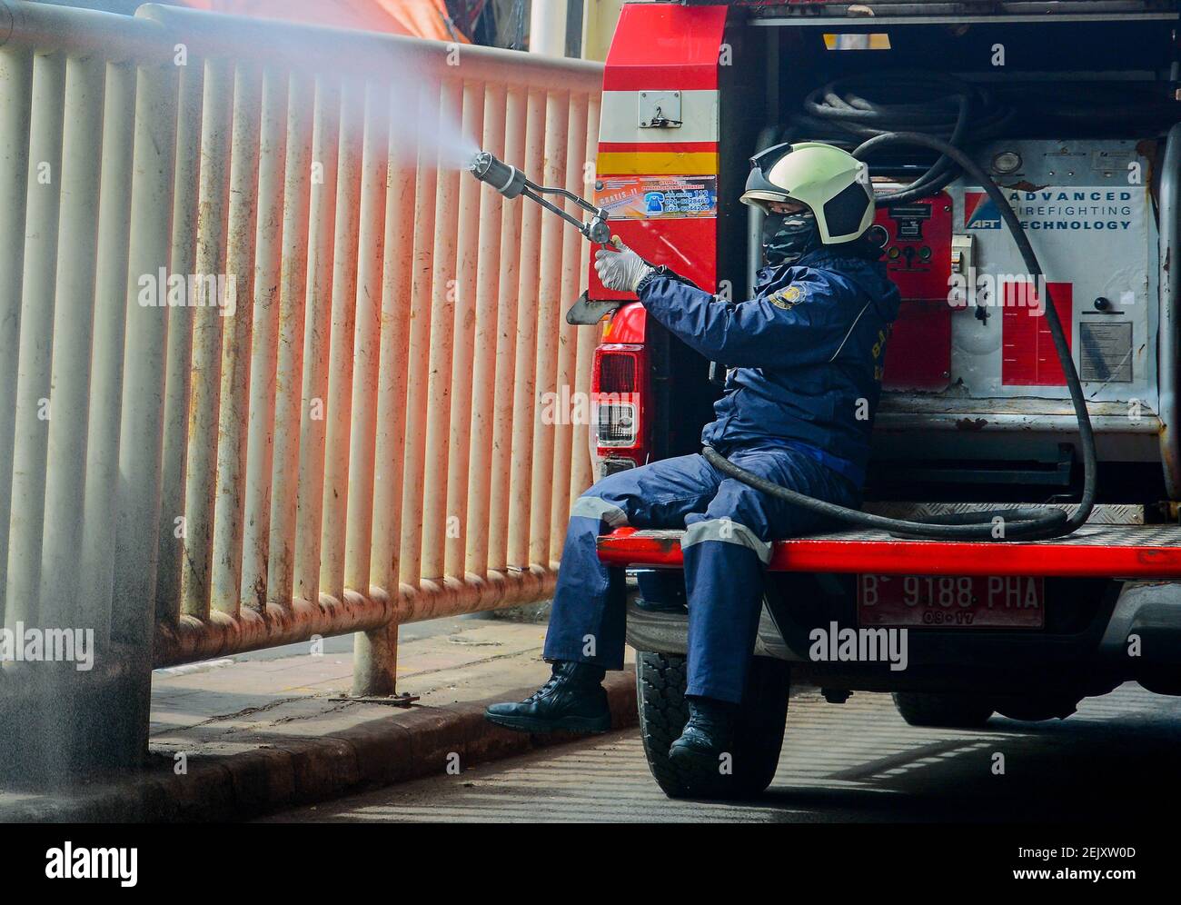 Indonesian firefighters spray disinfectant liquid at a market in ...