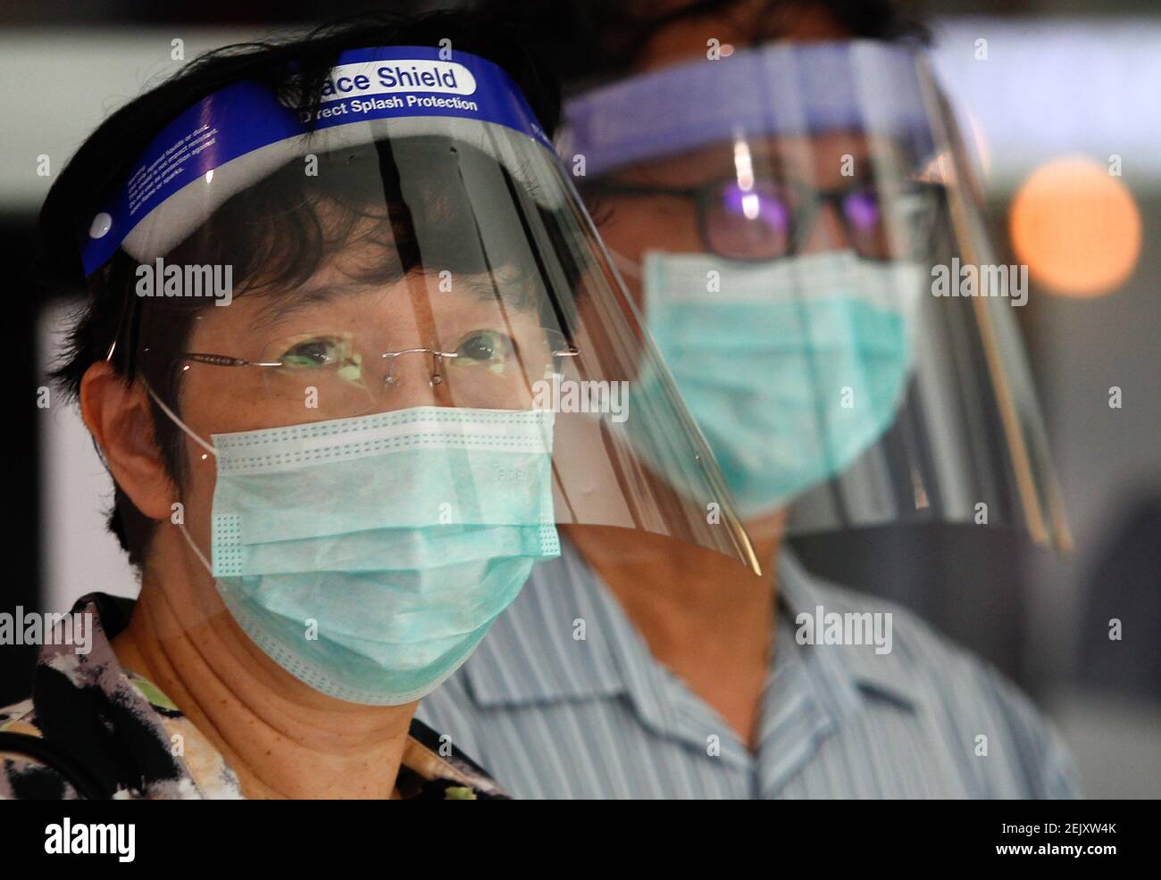 People wear face shields as a precaution against the spread of ...